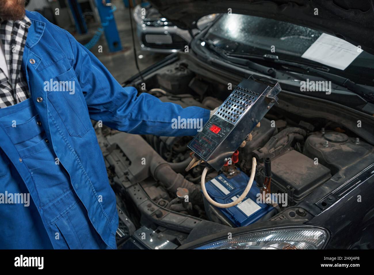 Man holding load plug for checking the battery Stock Photo - Alamy