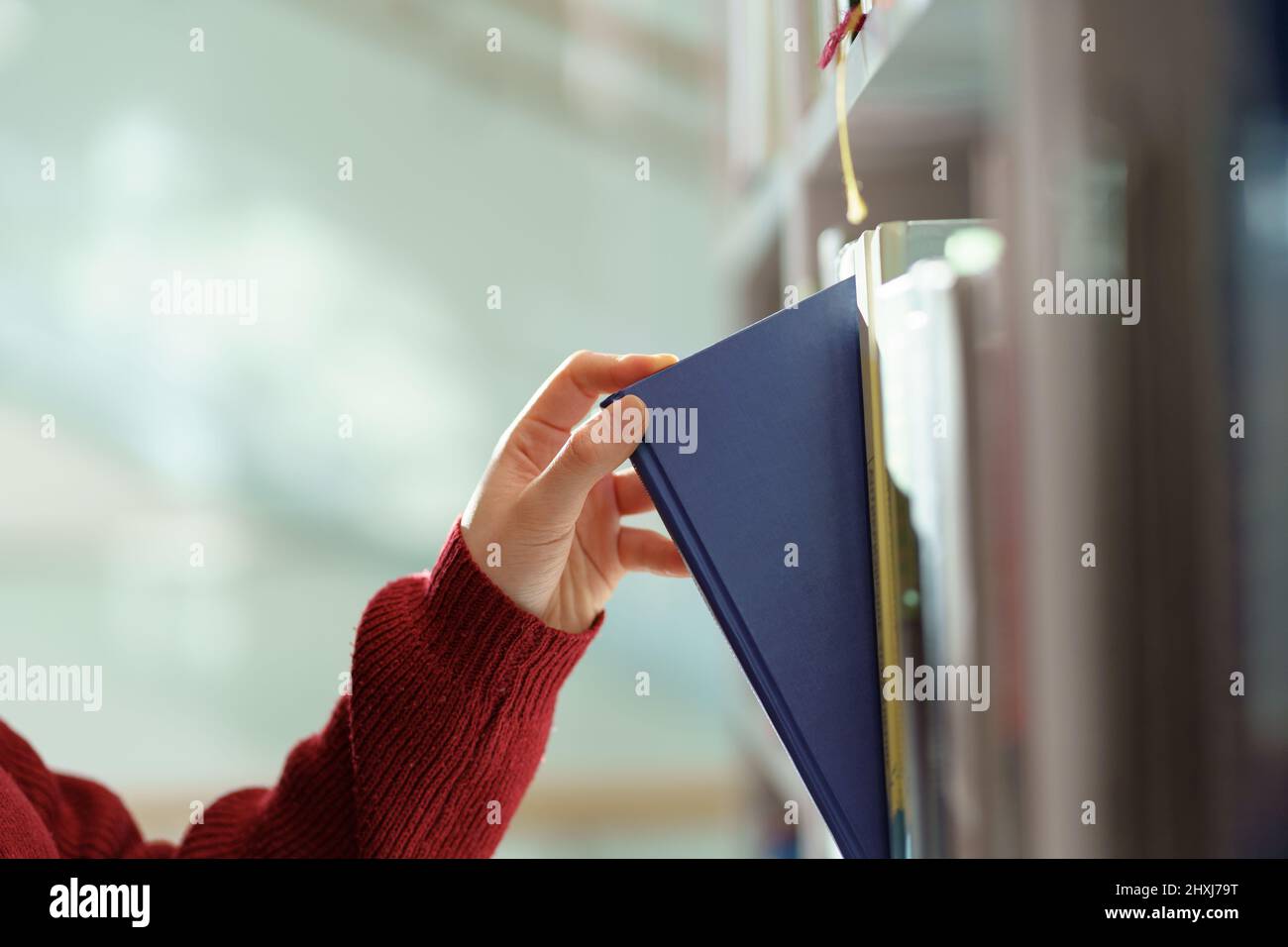 Hand pulling book from bookshelf hi-res stock photography and images ...