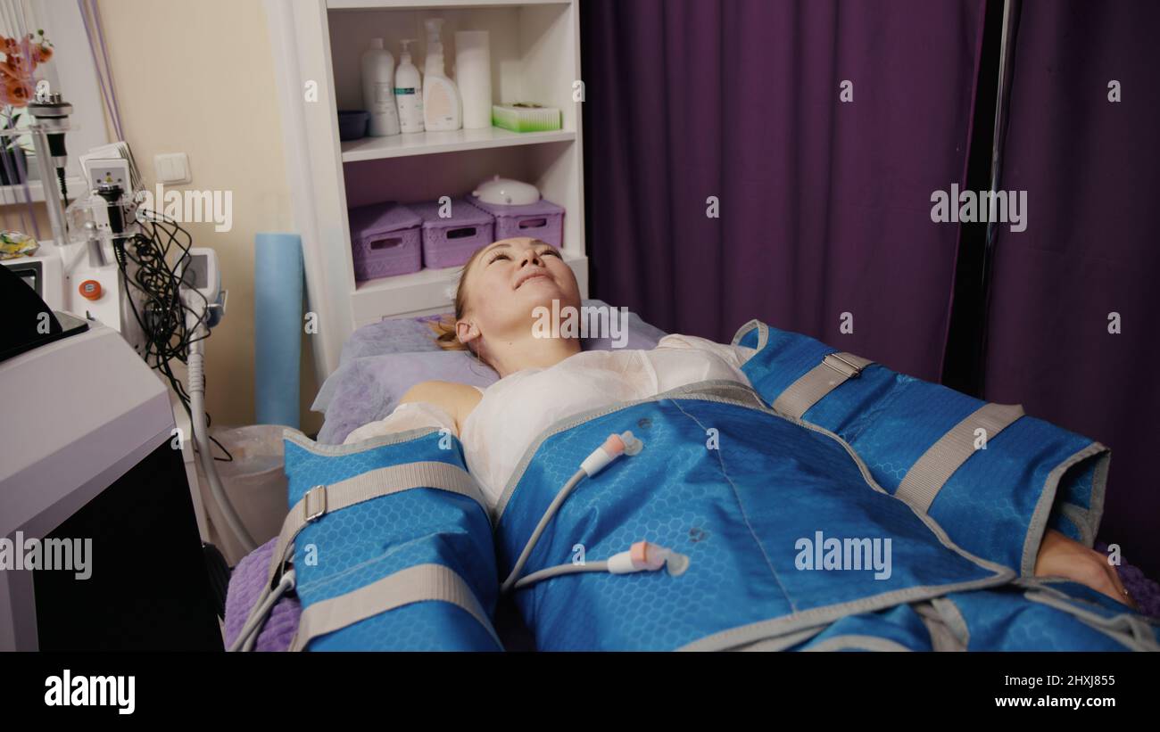 Woman receiving anti-cellulite pressotherapy lymphatic massage drainage ...