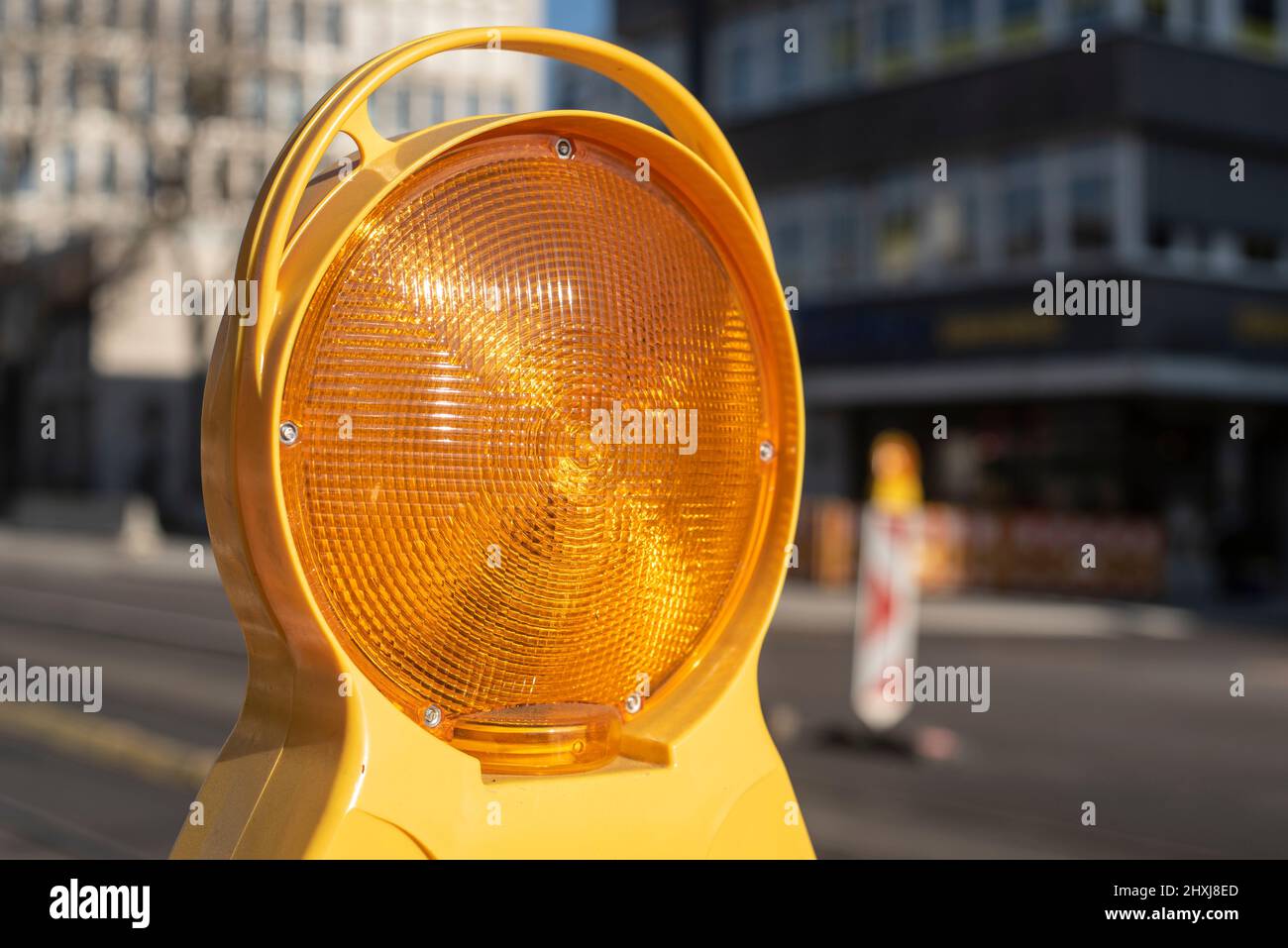 close-up of the yellow reflector lamp at a warning sign in a city ...