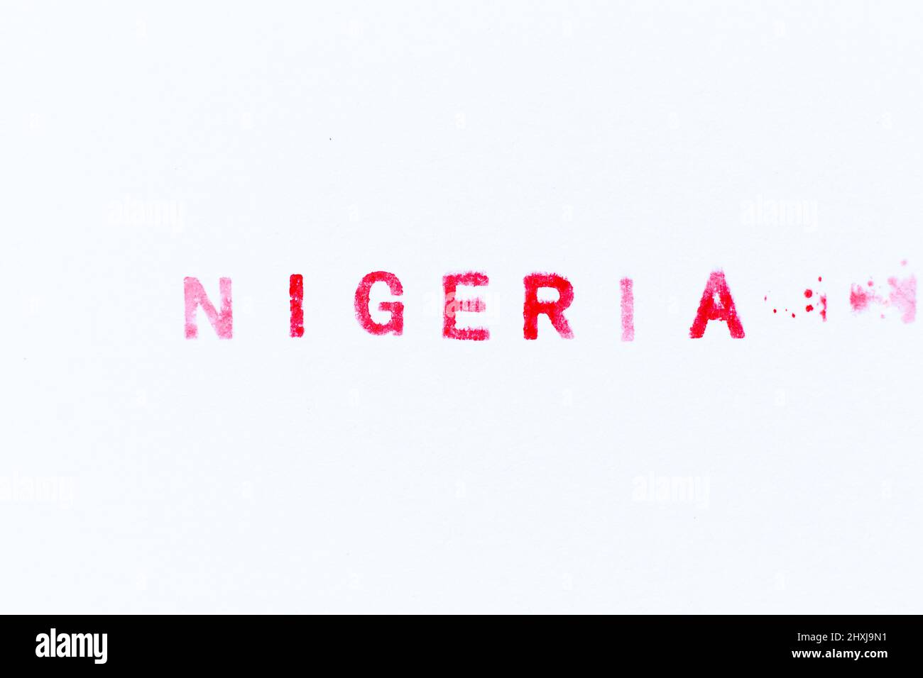 Red color ink rubber stamp in word nigeria on white paper background ...
