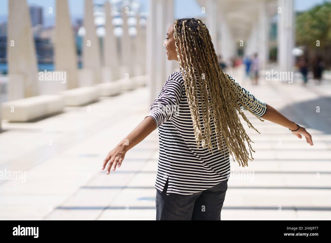 Young black woman moving her coloured braids in the wind. Typical ...