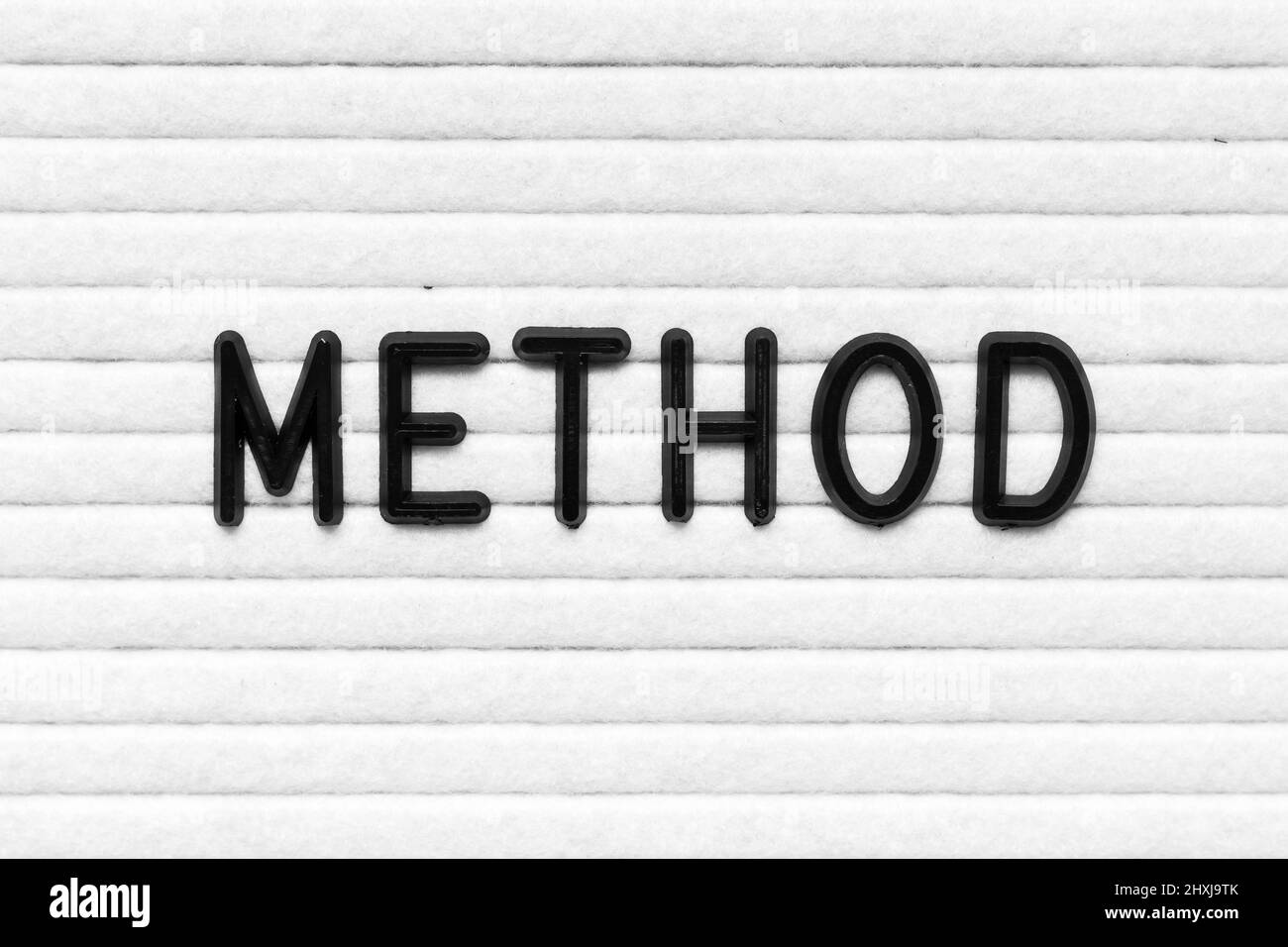Black alphabet letter in word method on white felt board background ...
