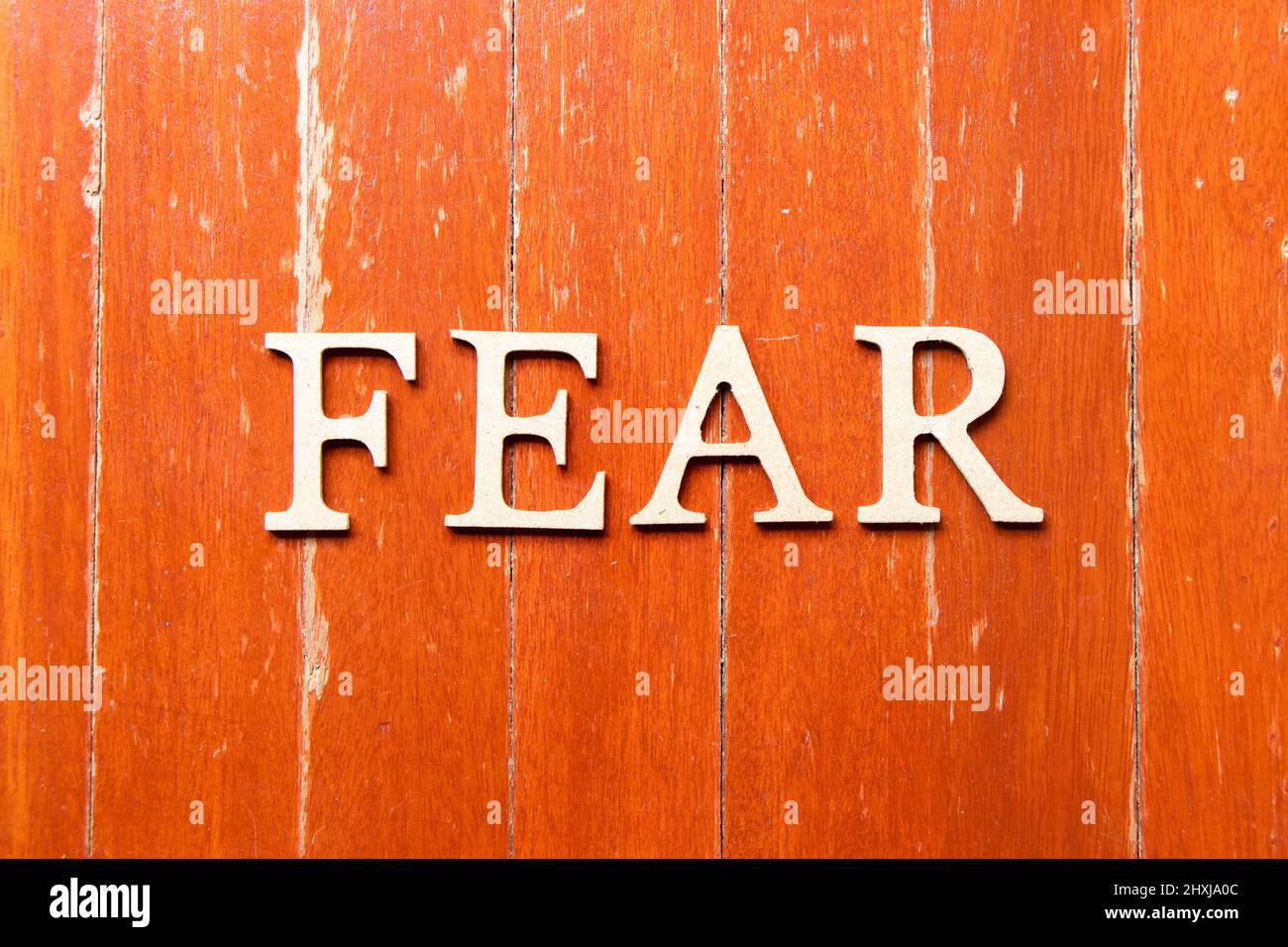 Alphabet letter in word fear on old red color wood plate background ...