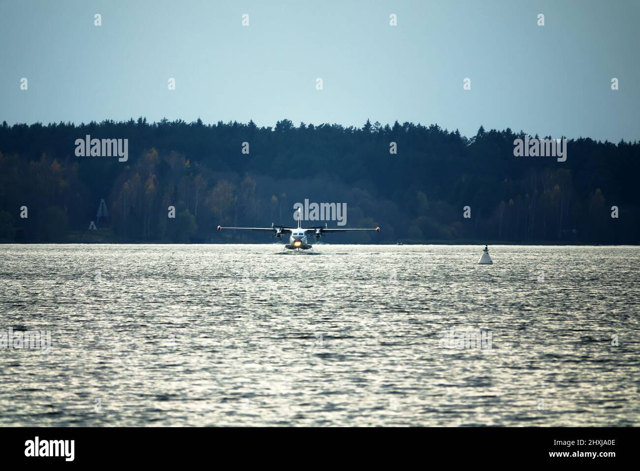 The Twin-engine seaplane a seaplane rises from water, from the forest ...