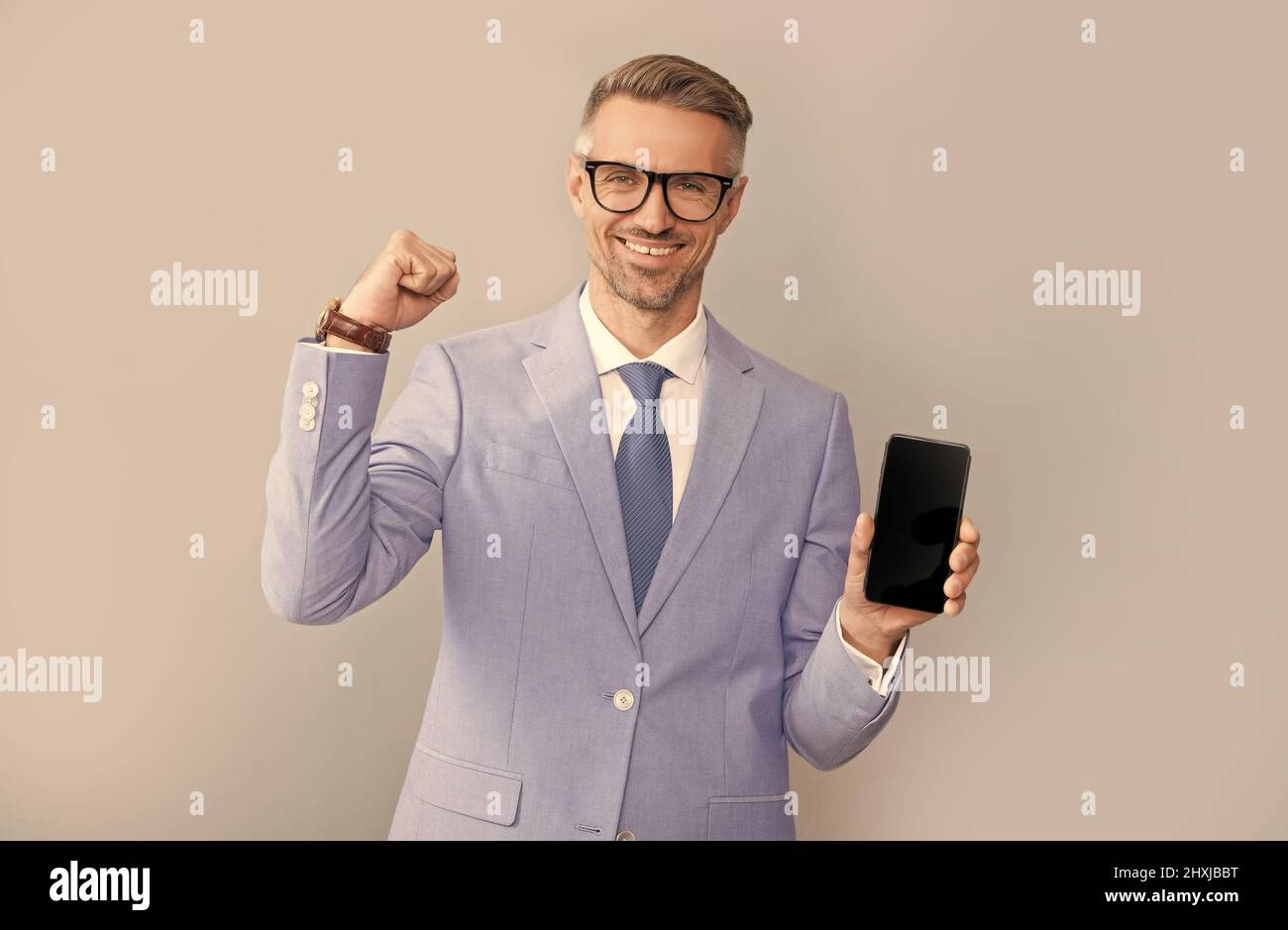 happy grizzled man showing phone screen in suit and glasses, new app ...