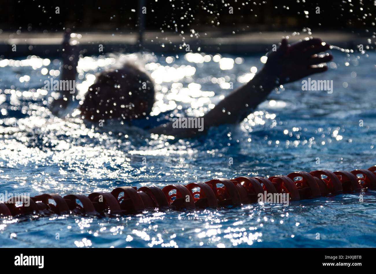 Bohmte, Germany. 13th Mar, 2022. A bather swims at the Bohmte outdoor ...