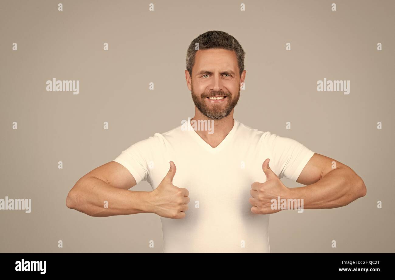 Double thumbs ups. Happy man give thumb sign. Handsome guy show thumbs ...
