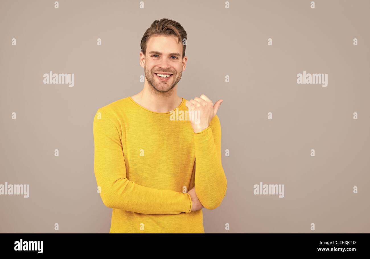 Advertising. Advertising man. Happy guy point finger aside grey ...
