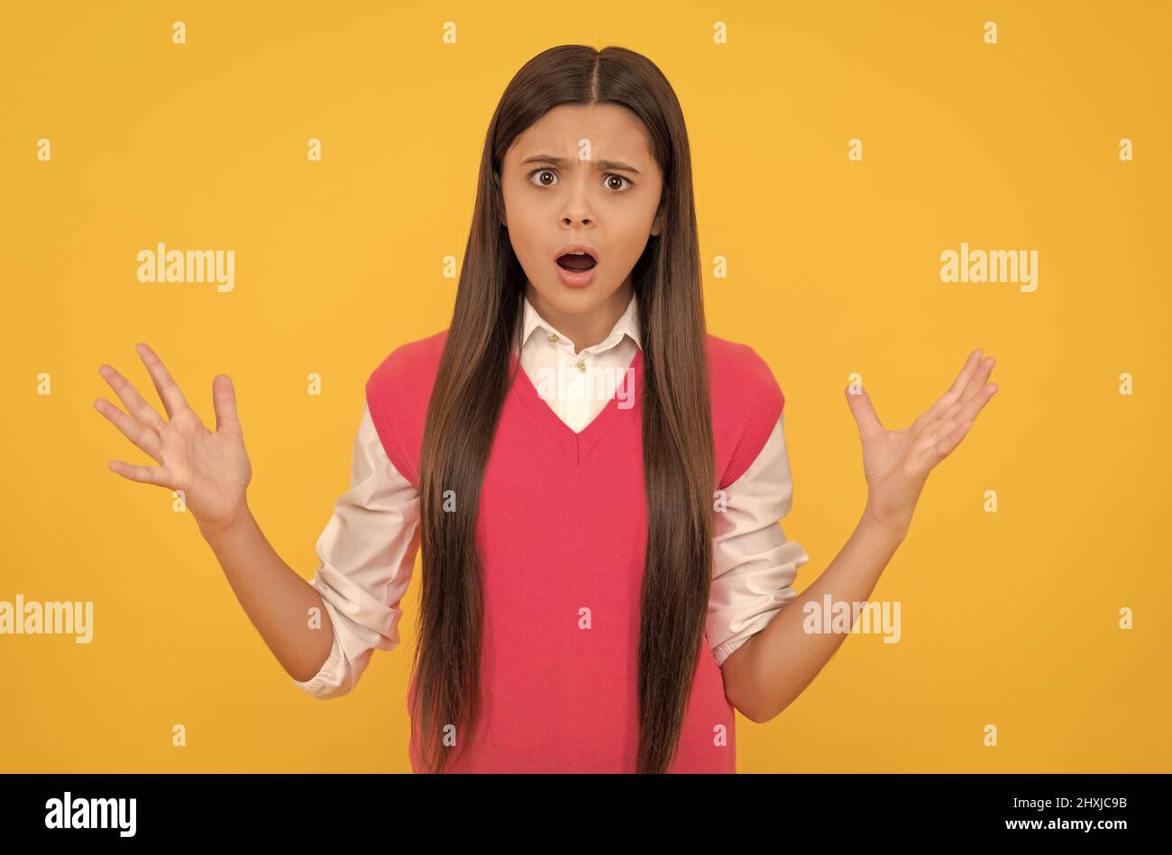 shocked teen school girl smiling with long hair on yellow background ...