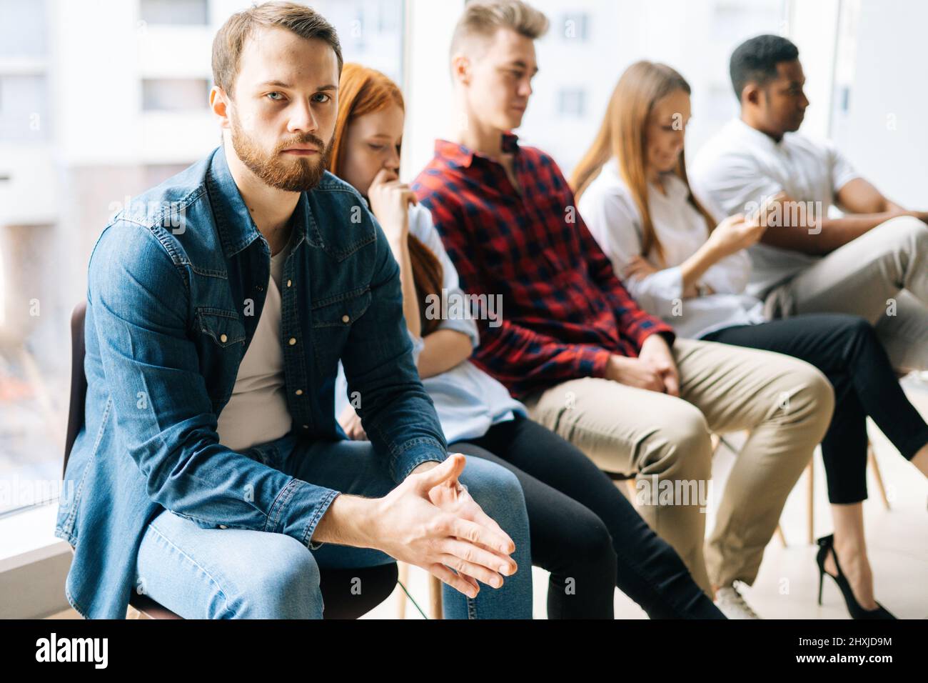 Portrait of stressed young man job candidates looking at camera waiting ...