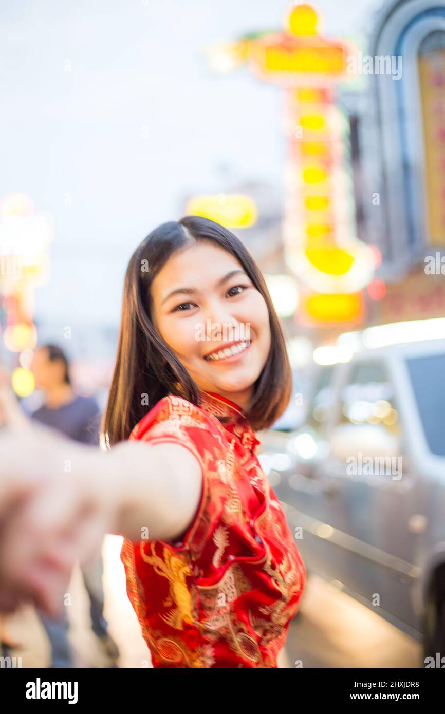 Chinese women travel with chinese new year costume leading man hand to ...