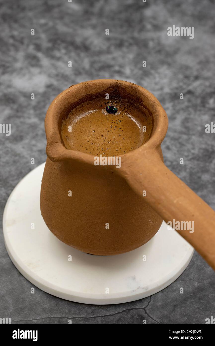 Turkish coffee in an earthen pot on a dark background. Traditional ...