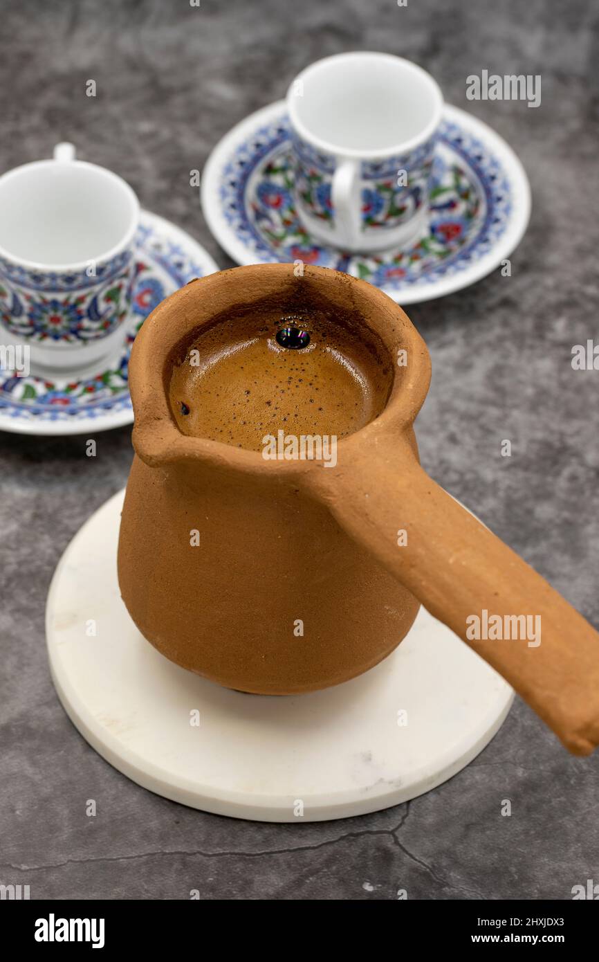 Turkish coffee in an earthen pot on a dark background. Traditional ...