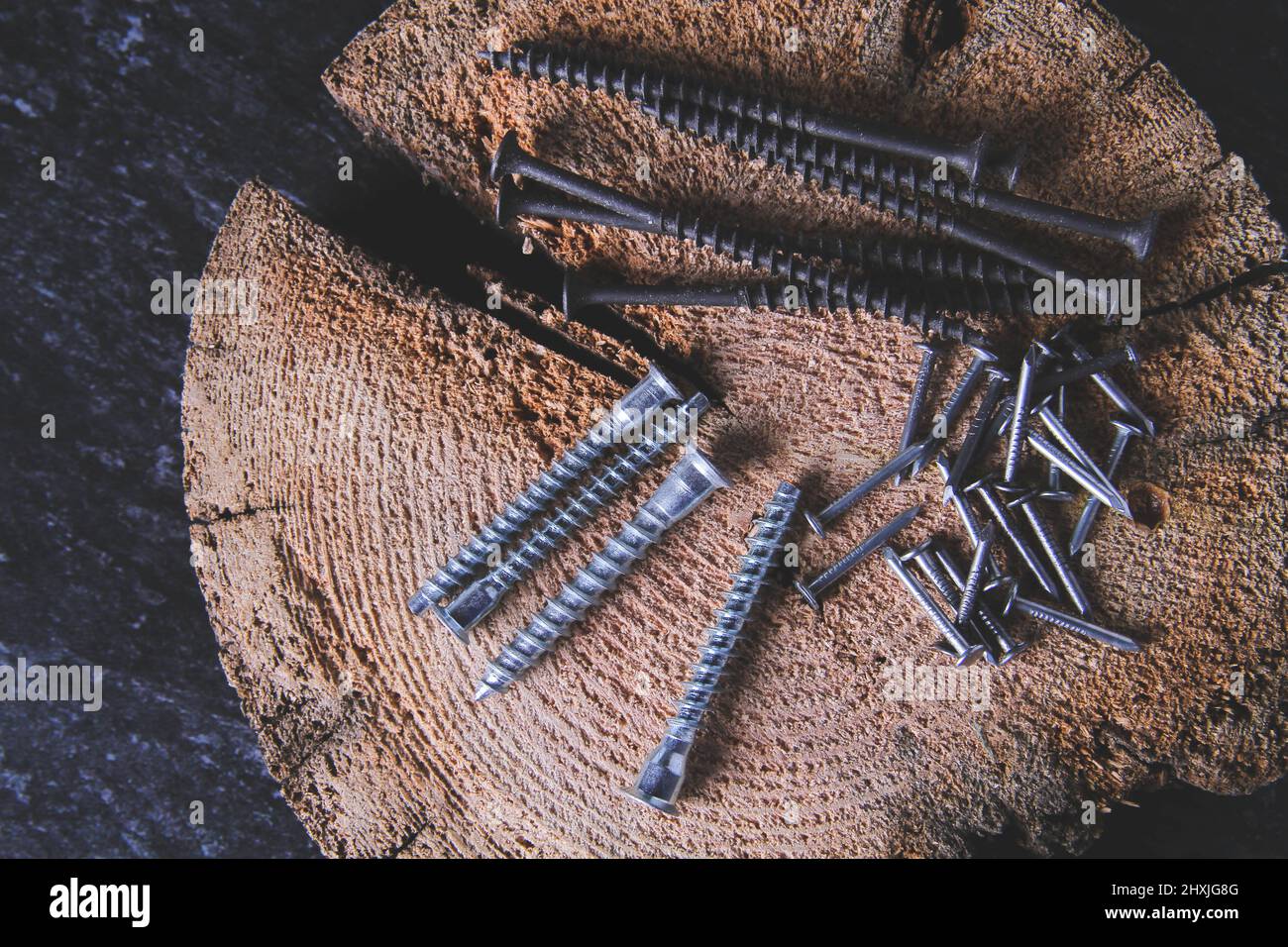 Fasteners for wood. Self-tapping screws on a wooden table. Nails and ...