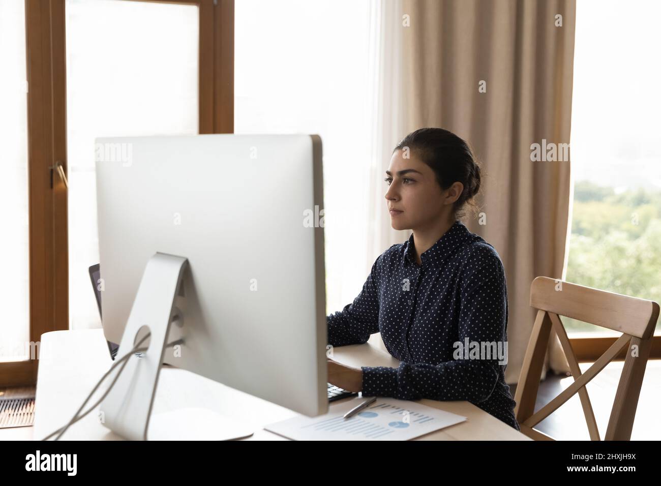 Indian businesswoman think on report on pc screen at workplace Stock ...