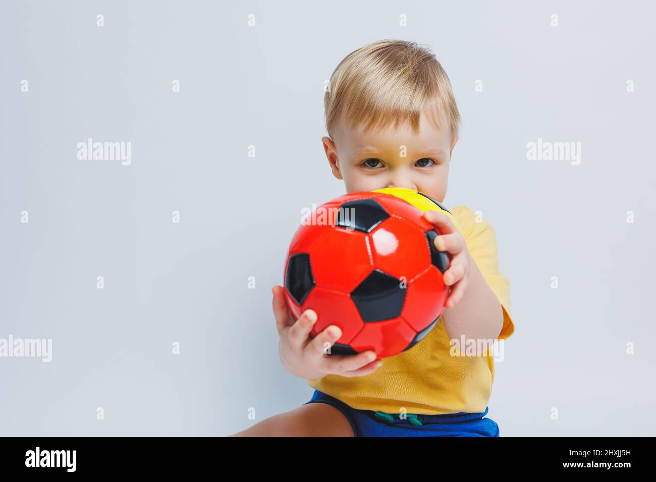 Little european boy, fan or player in yellow and blue uniform with a ...