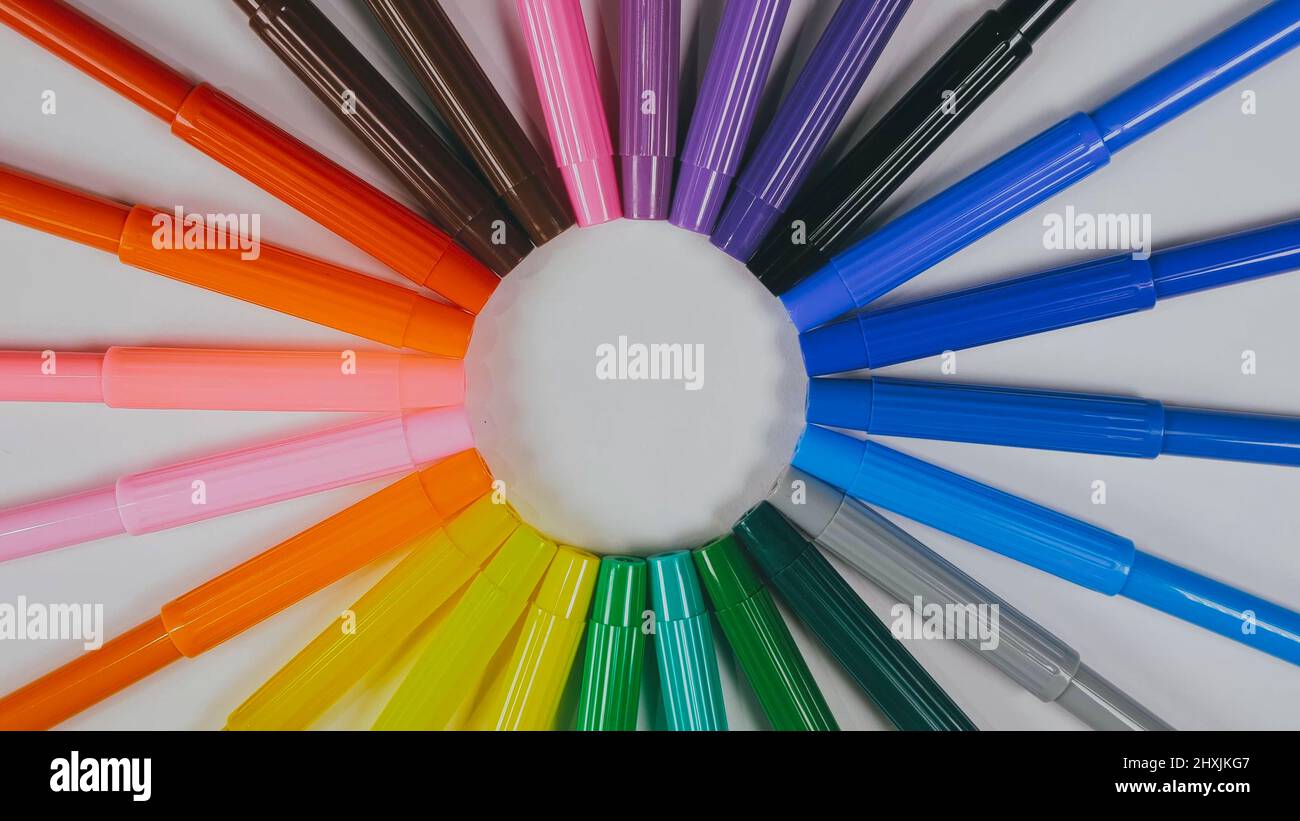 Many colored pencils are arranged around the edges of the image as a ...
