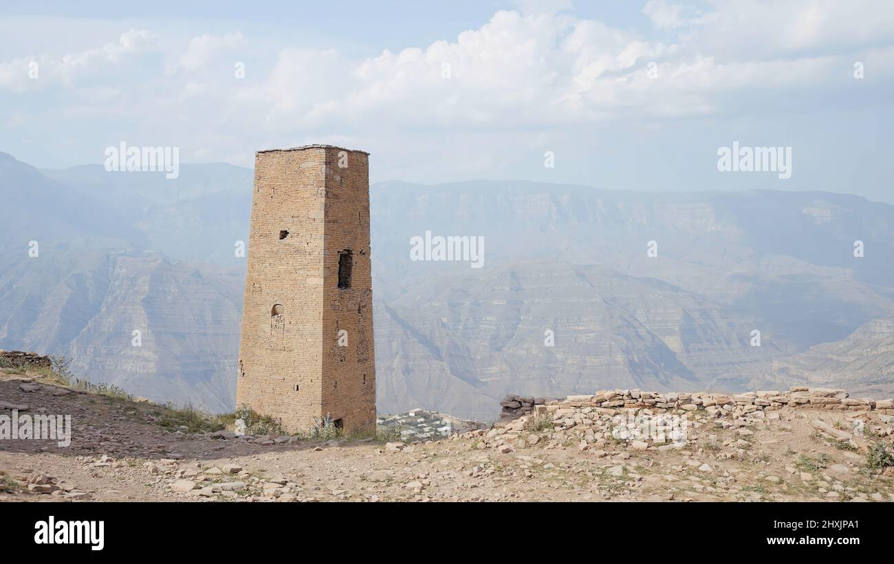 Ruined old stone tower on mountains background. Action. Ancient ...
