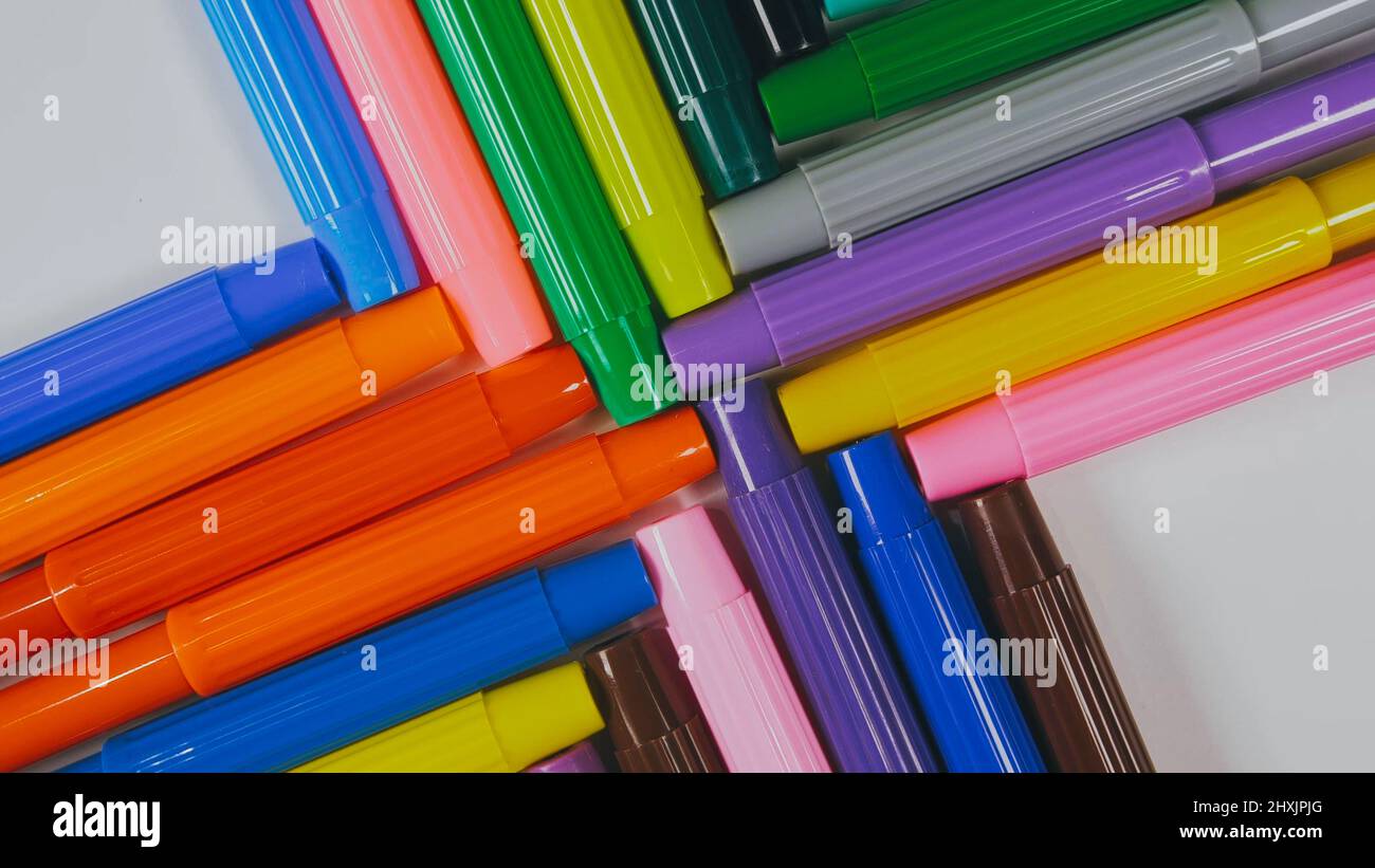 Many colored pencils are arranged around the edges of the image as a ...