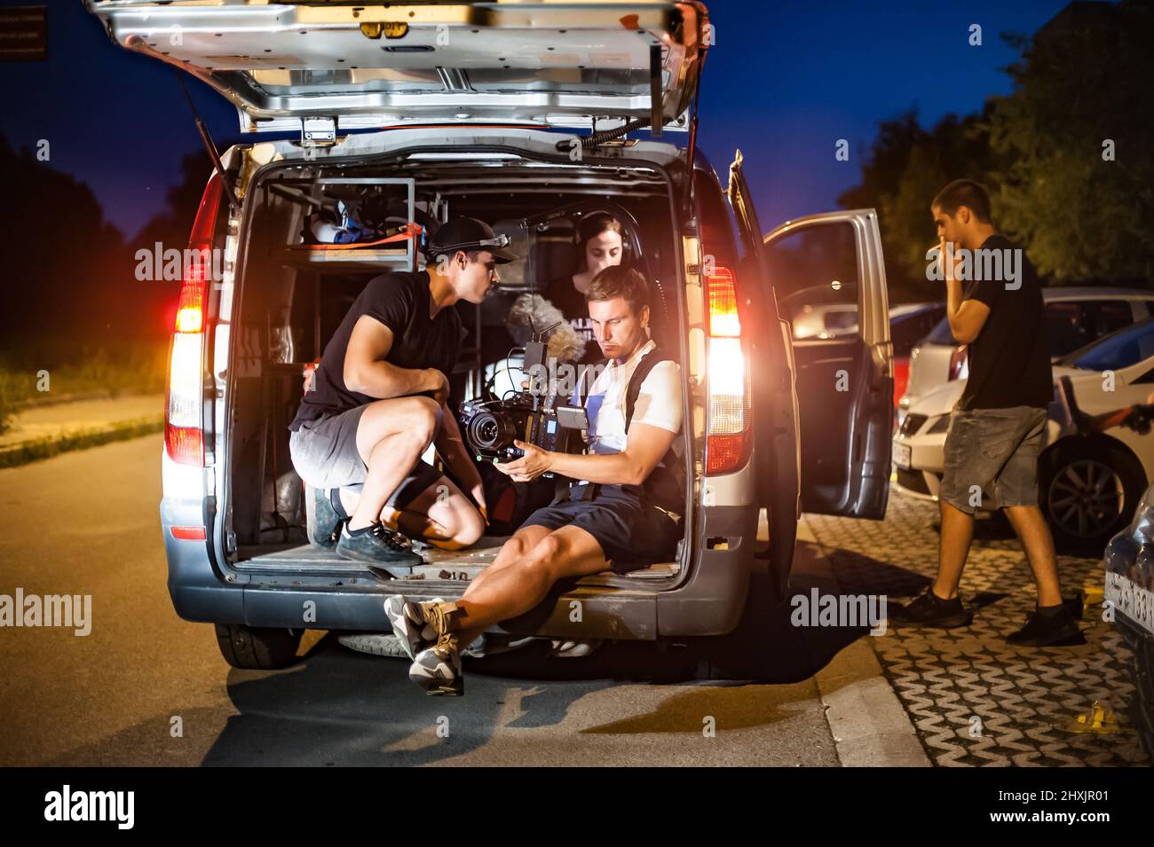 Behind scene improvisation. Cameraman film crew team from trunk of van ...