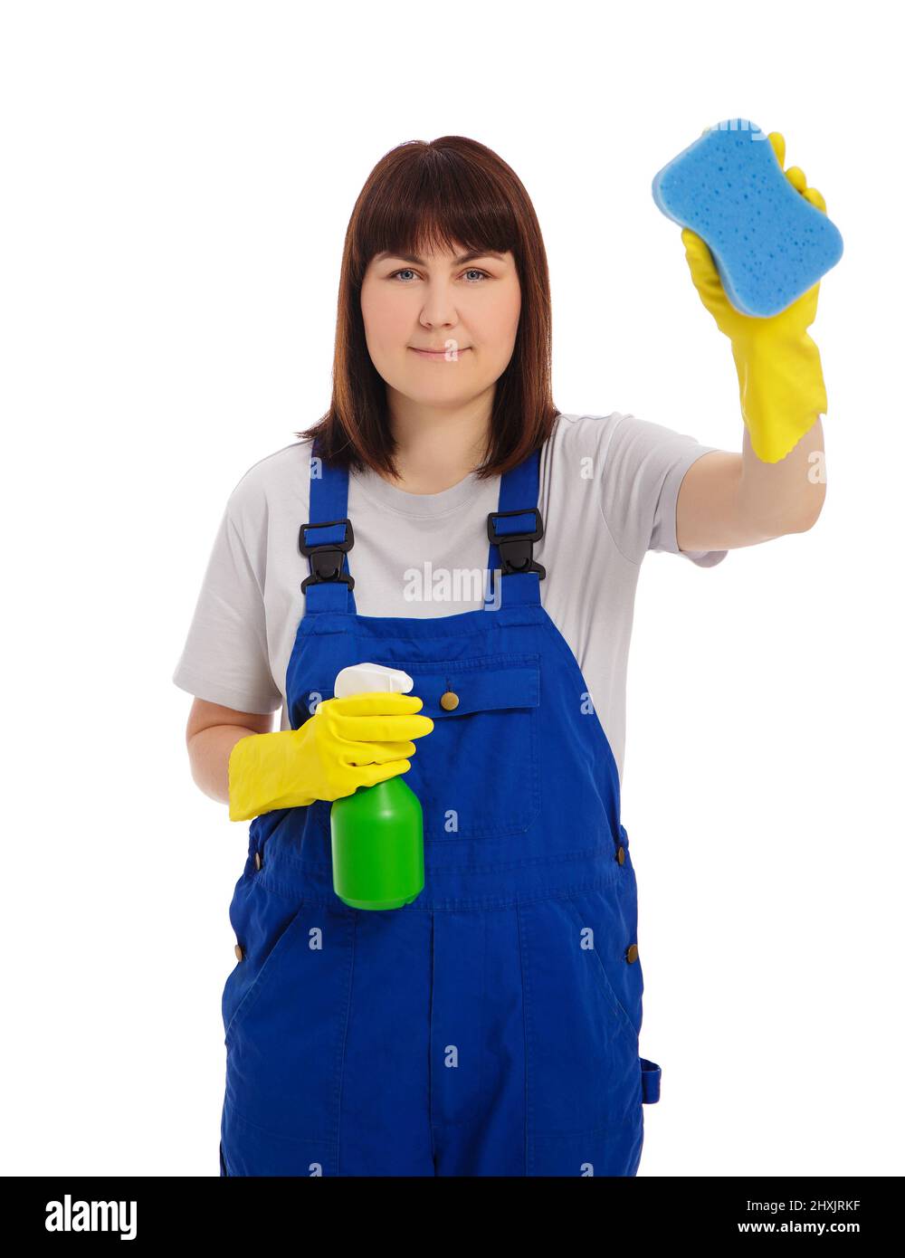 portrait of professional female cleaner in blue uniform cleaning window ...