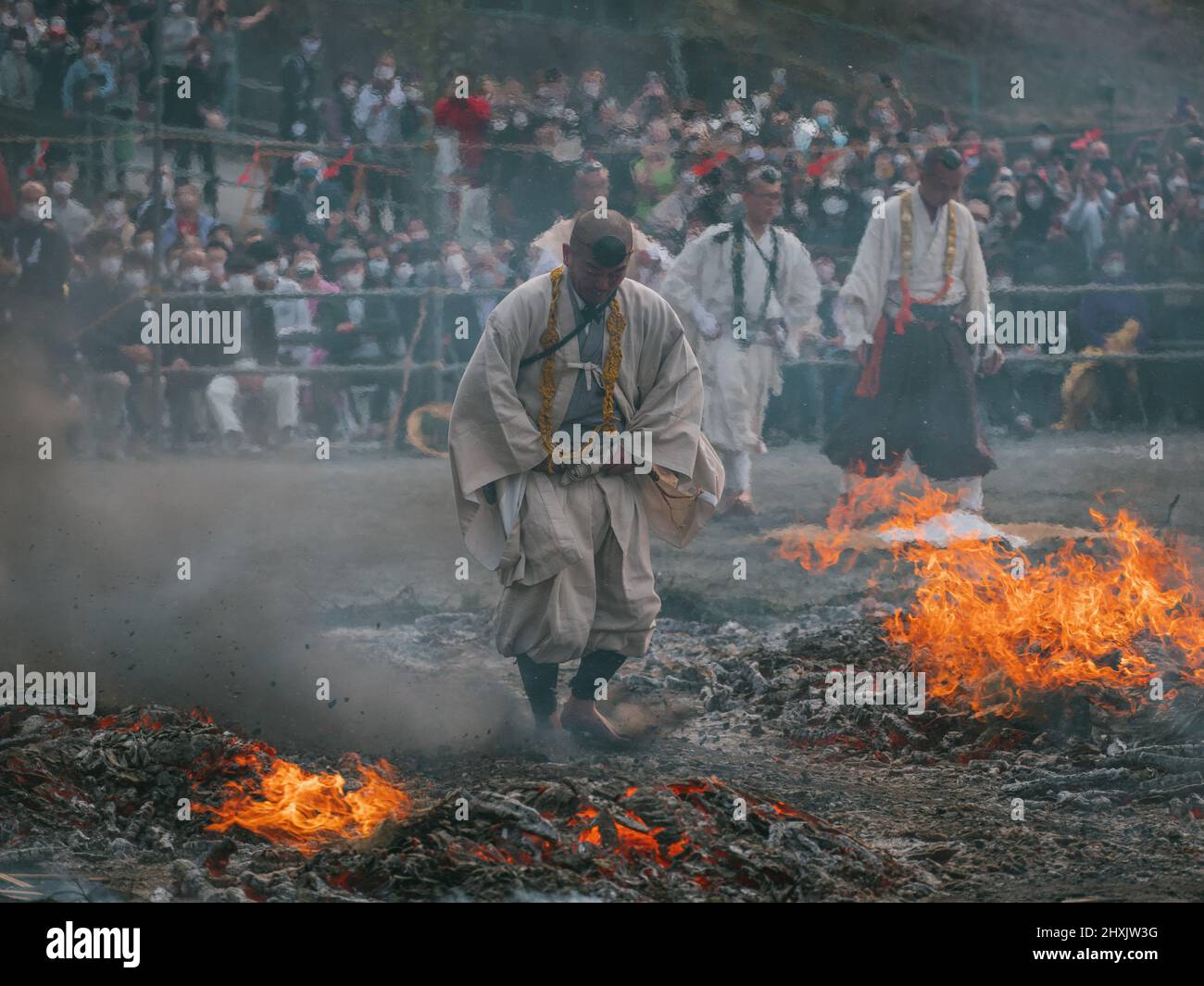 A yamabushi walks over smoldering coals with barefoot at the fire ...