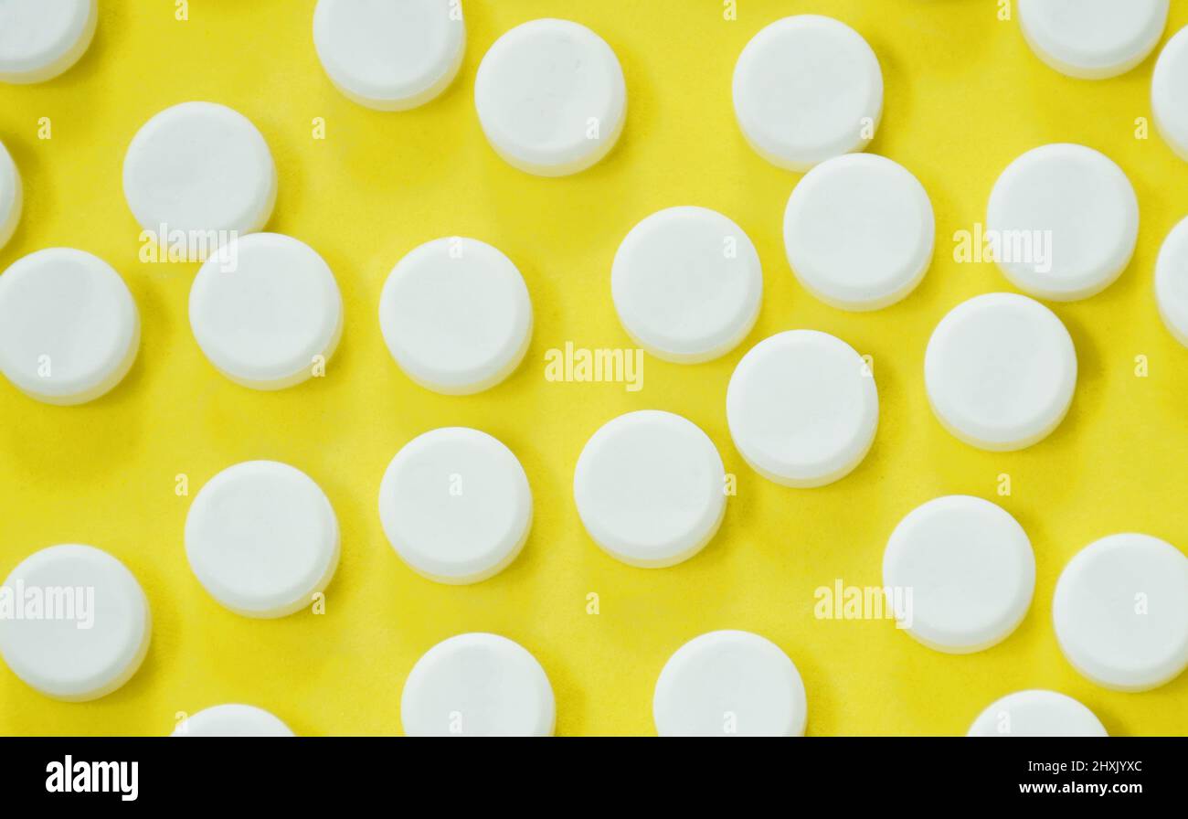 white tablet medicine arranging on yellow background Stock Photo - Alamy