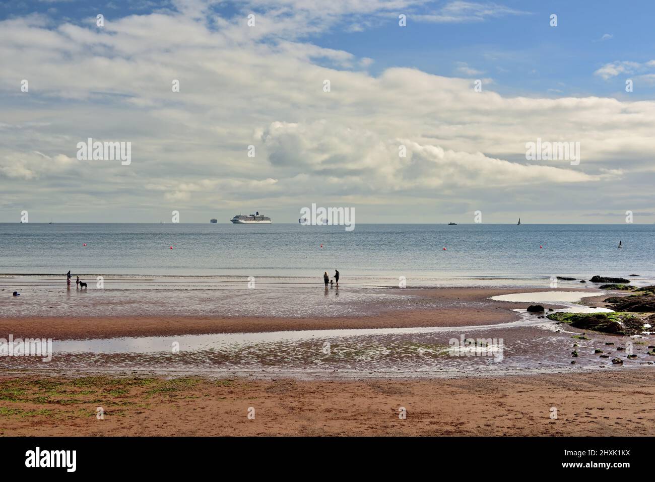 People on the beach and ships on the horizon at Goodrington Sands ...