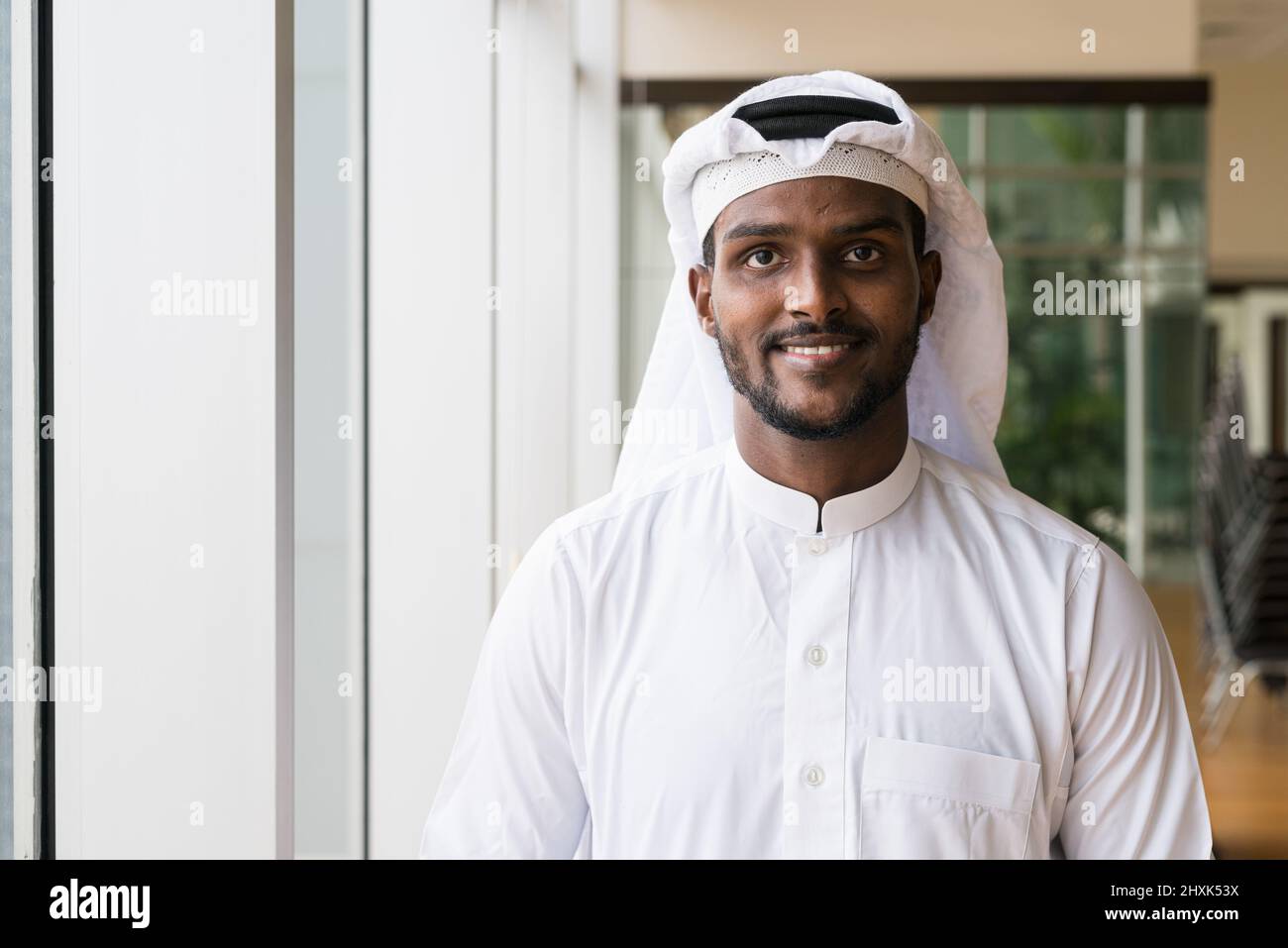 Portrait of young African Muslim man wearing religious clothing an ...