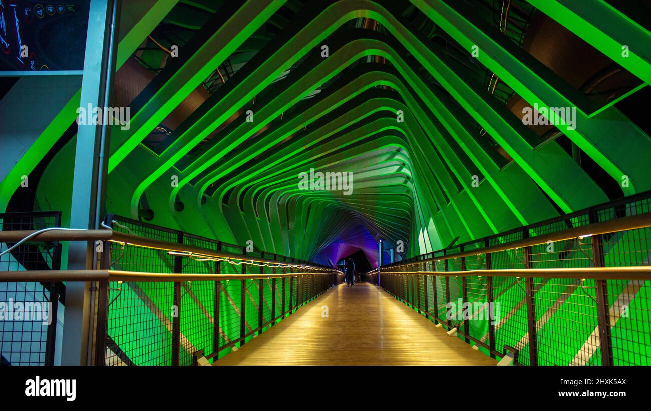 people pedestrian bridge covered in colorful neon lights in the urban ...