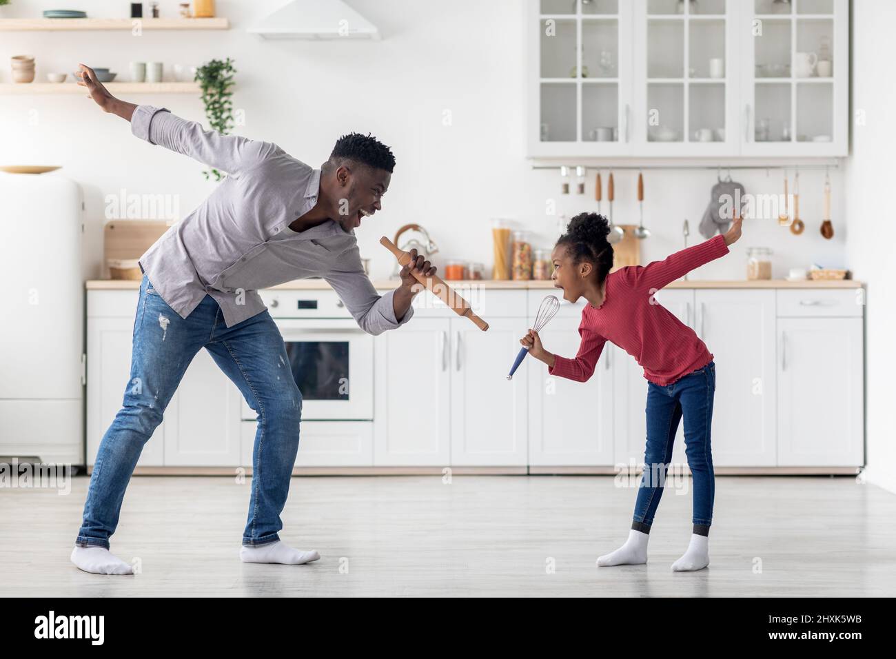 Talented african american father and daughter singing Stock Photo - Alamy