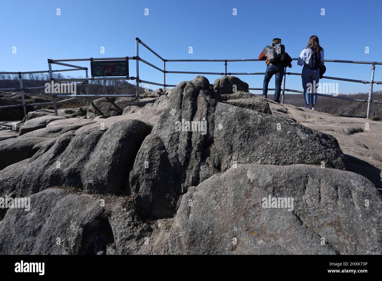 Thale, Germany. 13th Mar, 2022. Hikers enjoy the view on the Rosstrappe ...