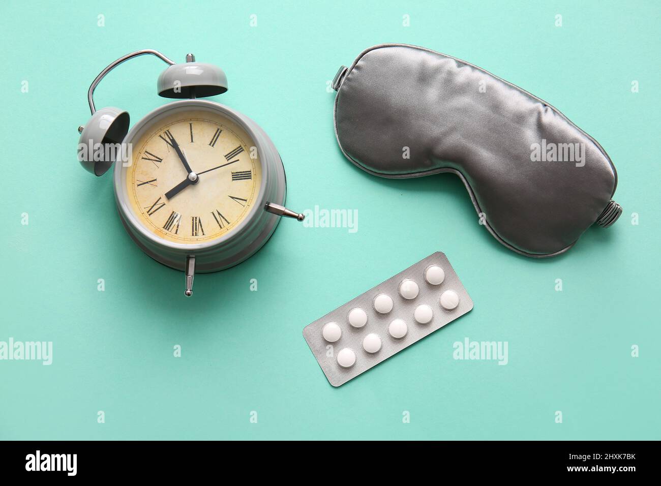 Sleep mask, pills and alarm clock on color background Stock Photo - Alamy