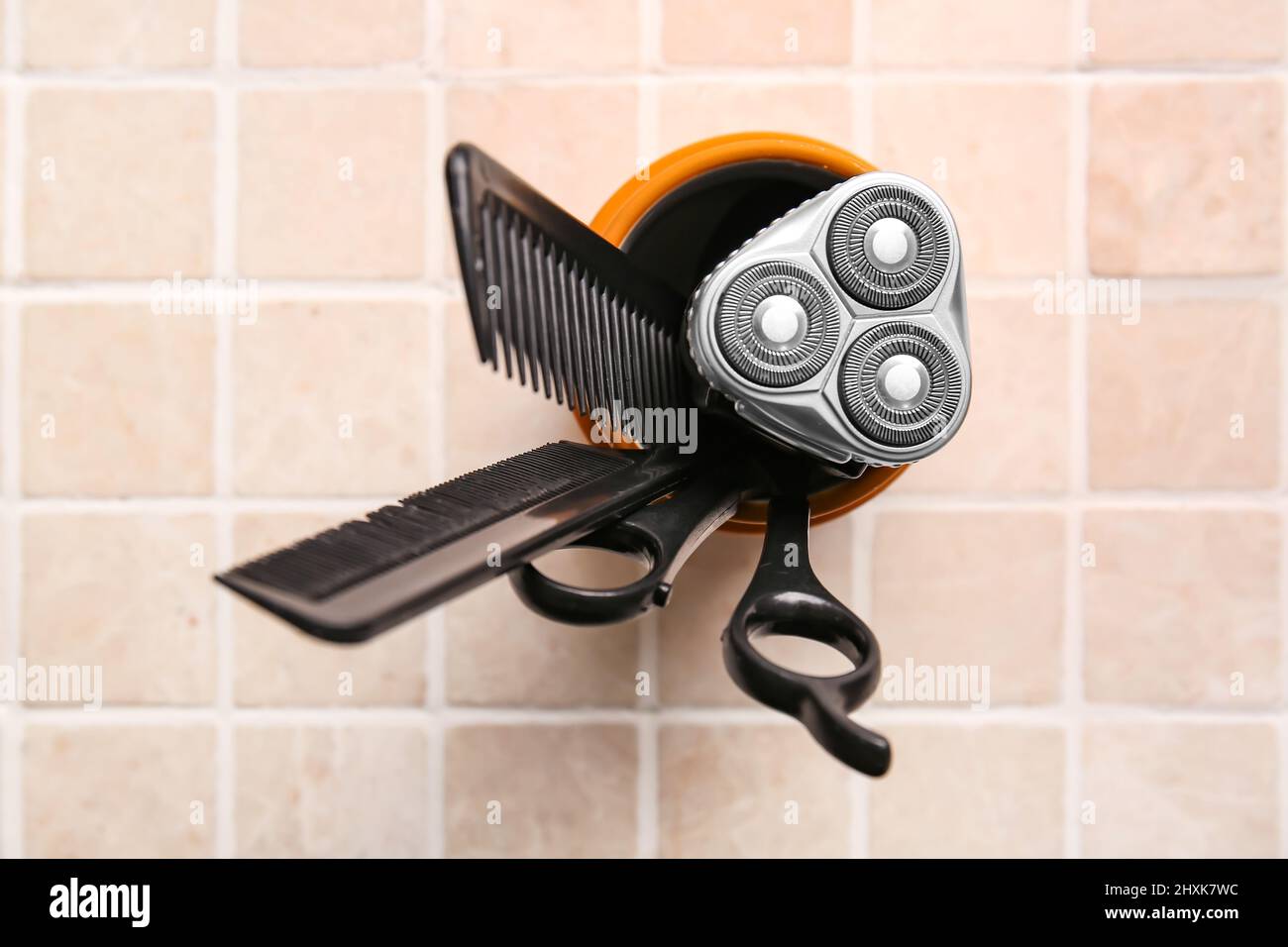 Modern electric shaver, scissors and comb on tile background Stock ...