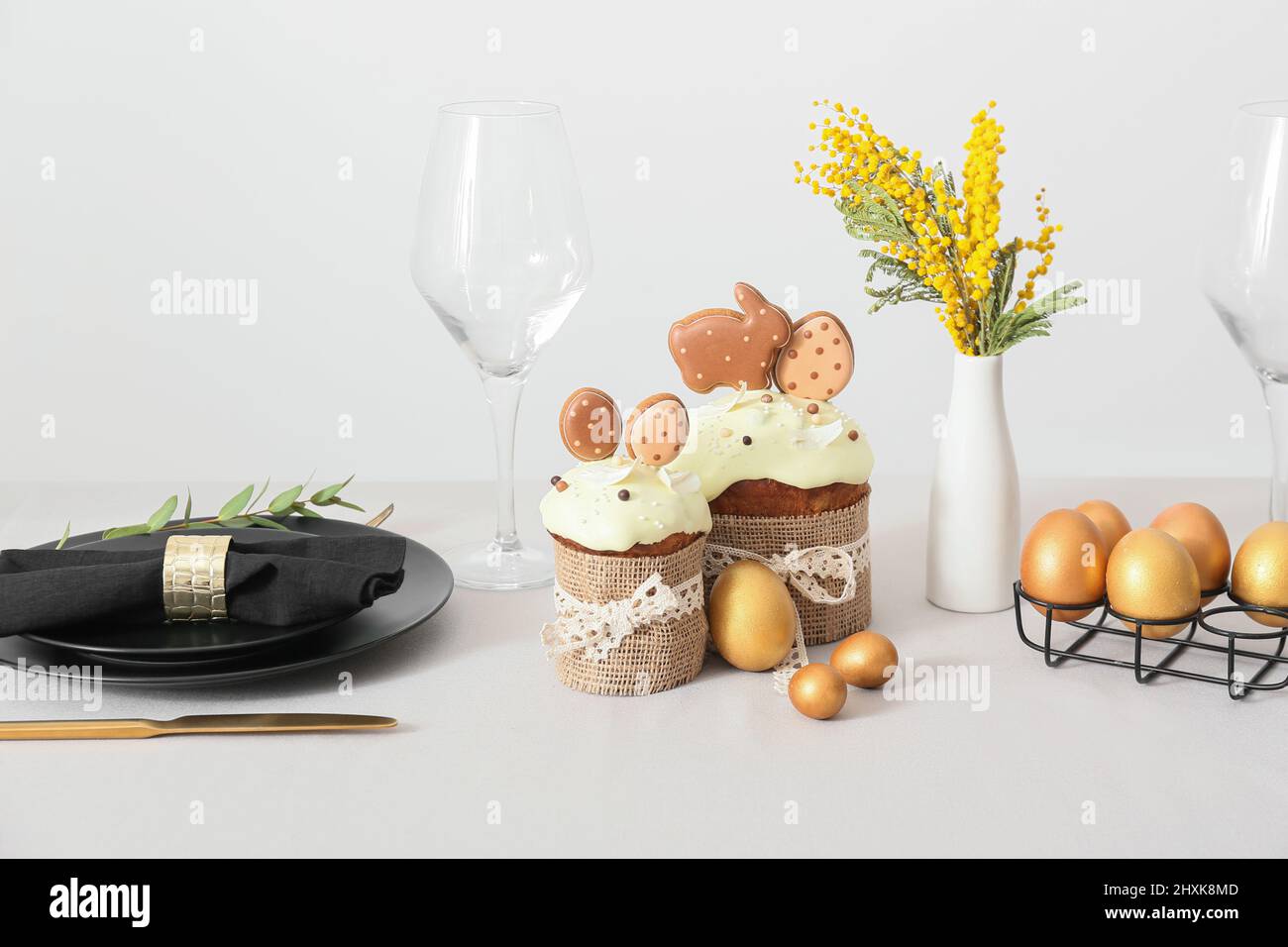 Beautiful Easter table setting with mimosa flowers near light wall ...