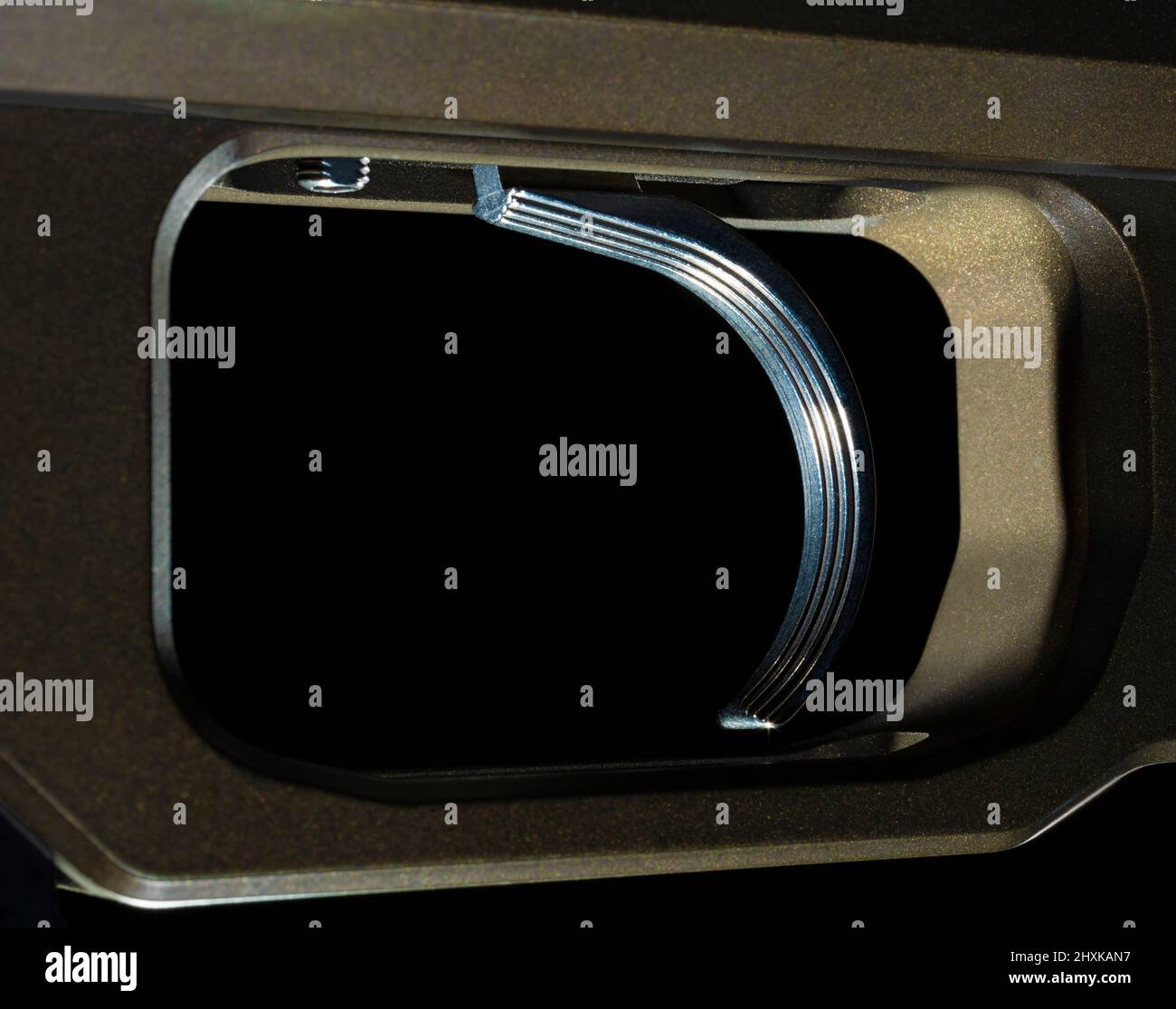 Black trigger on a rifle with a metallic copper finish Stock Photo - Alamy