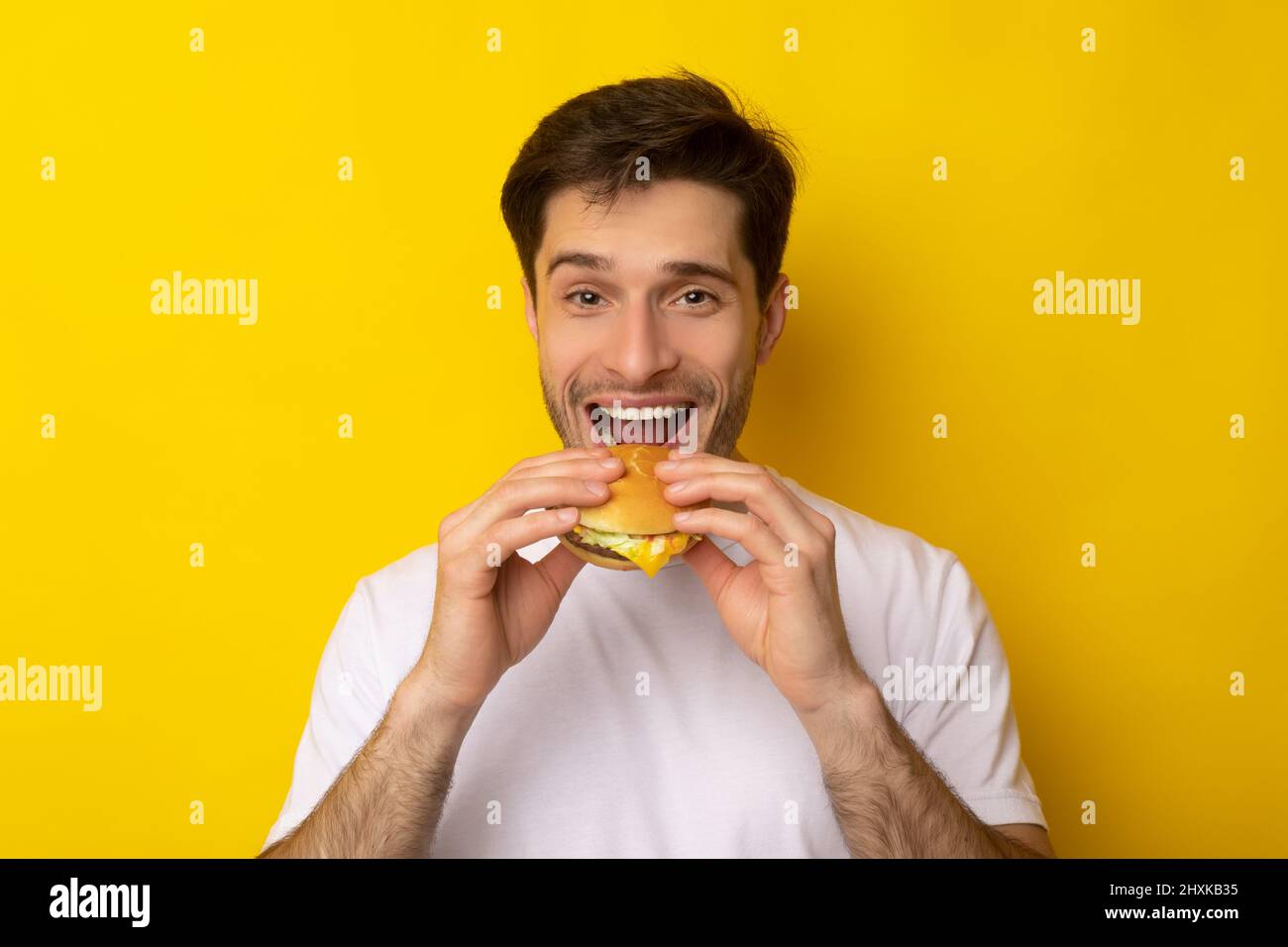 Adult man biting juicy hamburger hi-res stock photography and images ...