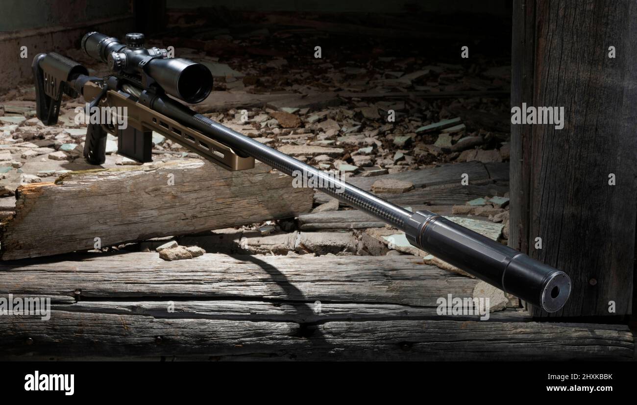 Bolt action rifle with scope and silencer in an abandoned building ...