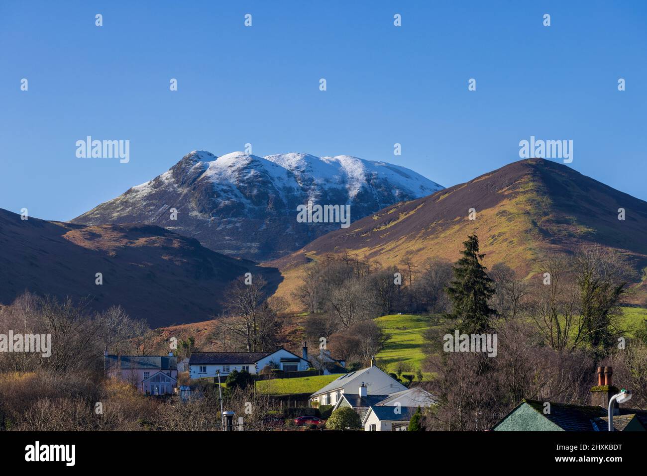 The village of Braithwaite with a snow capped Causey Pike in the winter ...