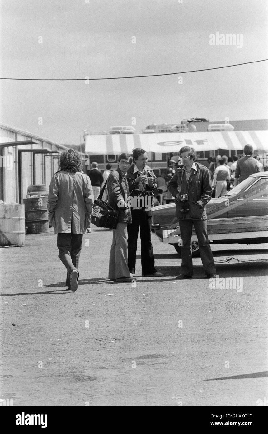 George Harrison walking past some photographers at the British Grand ...