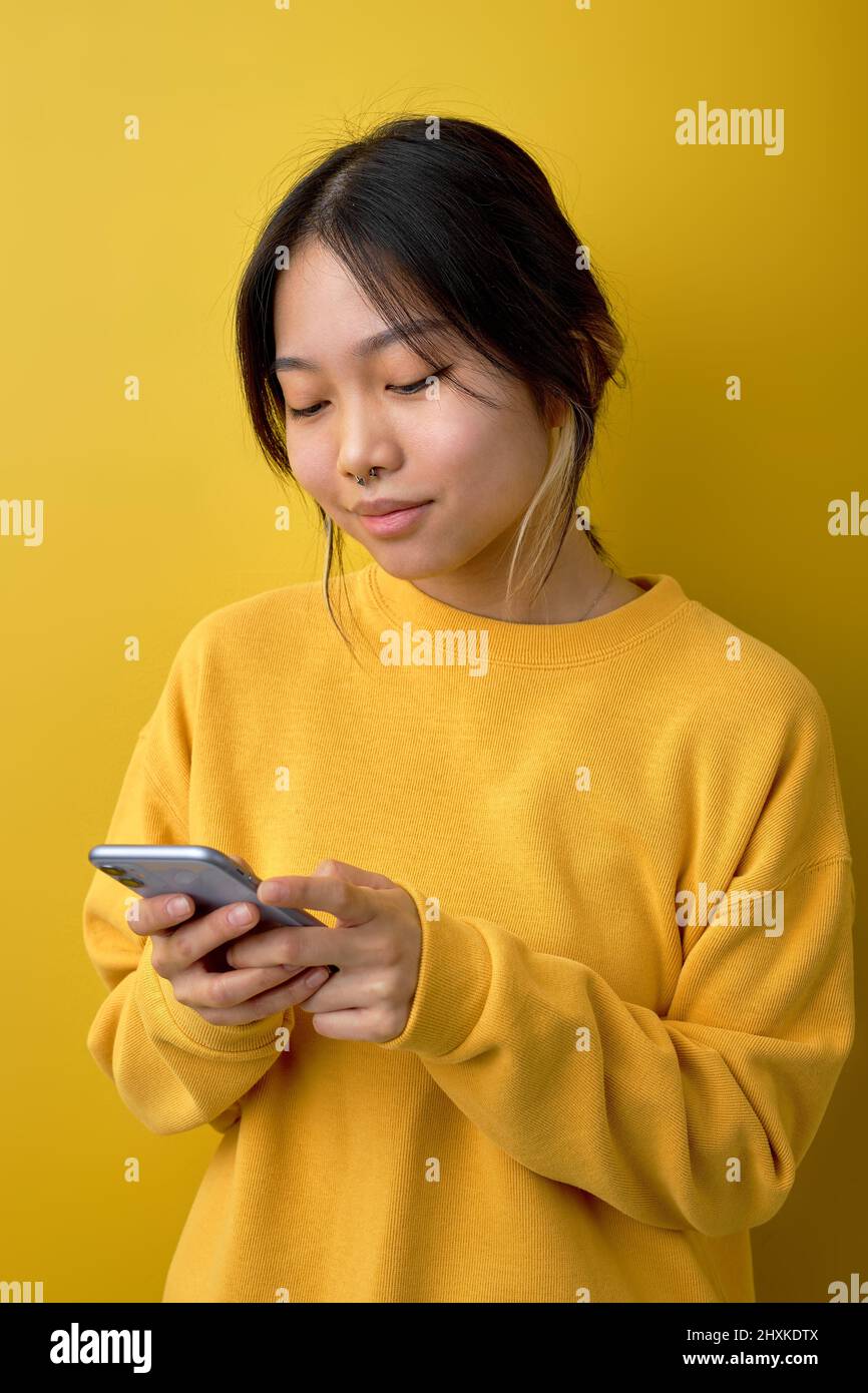 People And Technology Concept. Portrait of smiling shy young asian woman using smartphone ...