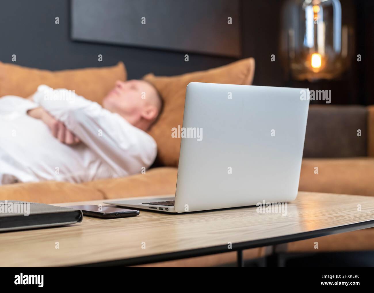 Exhausted tired businessman lying on sofa in office, relaxing after ...