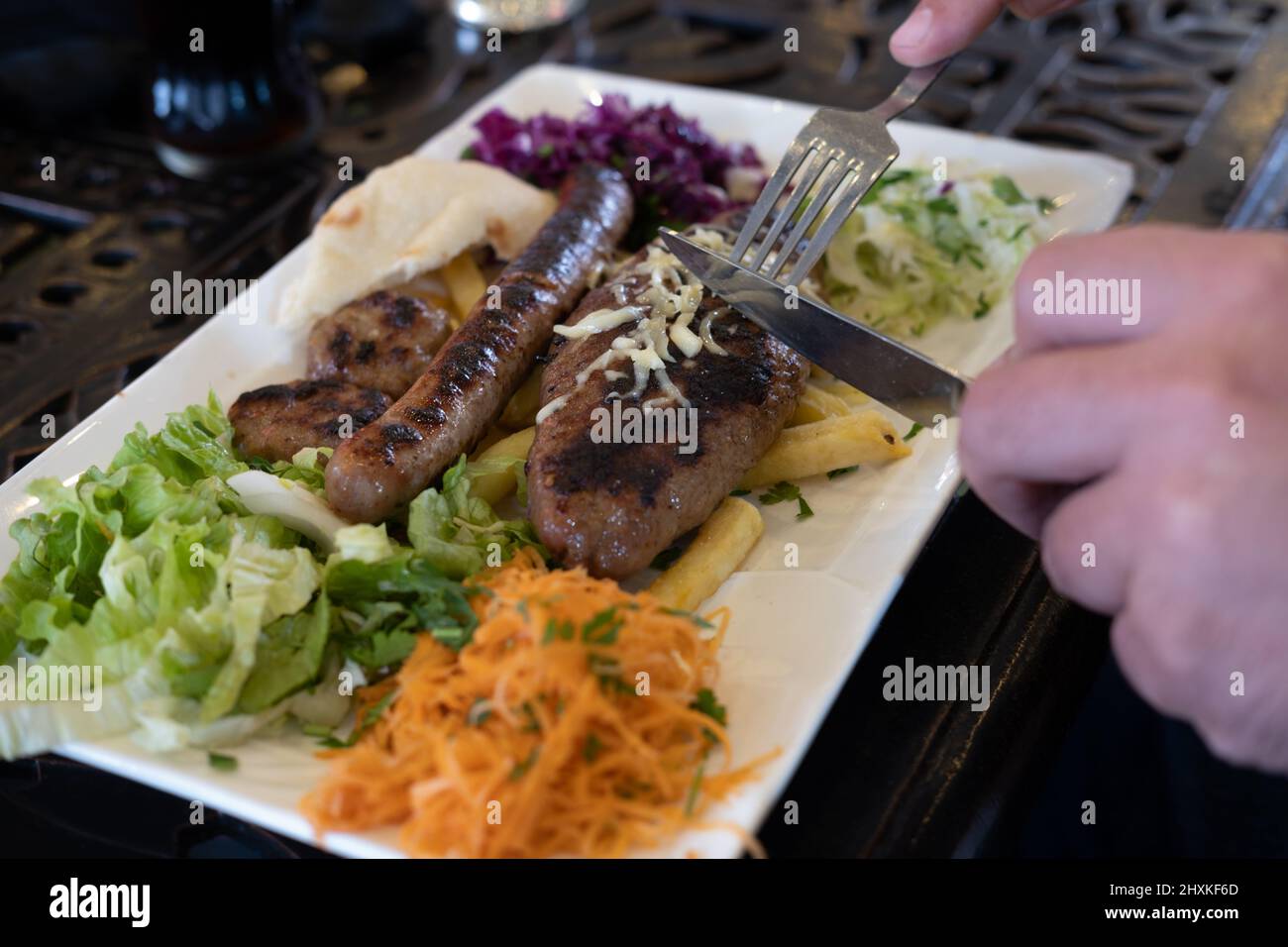 Different types of grilled or barbeque meat on the plate, cutting and ...
