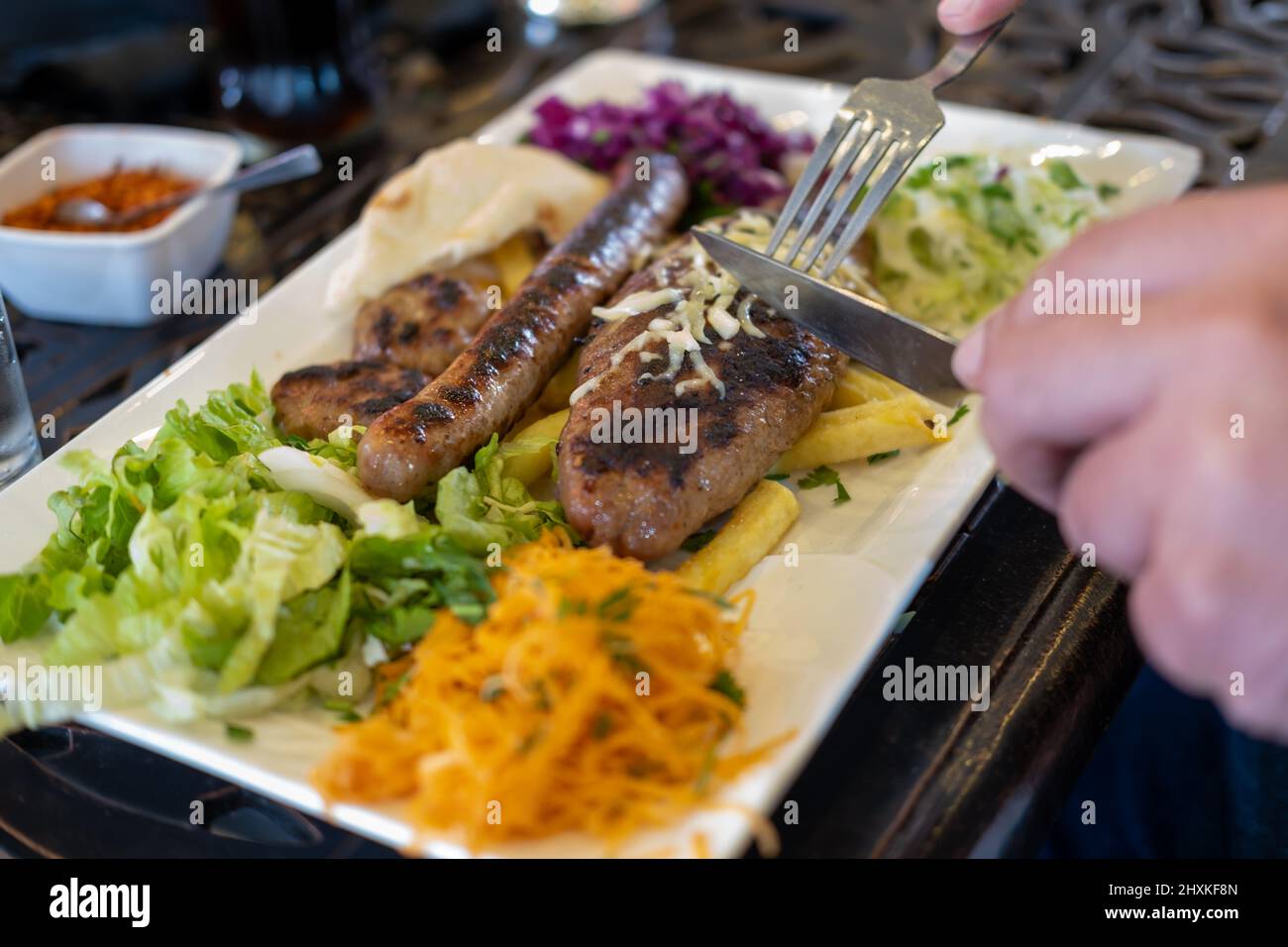 Different types of grilled or barbeque meat on the plate, cutting and ...