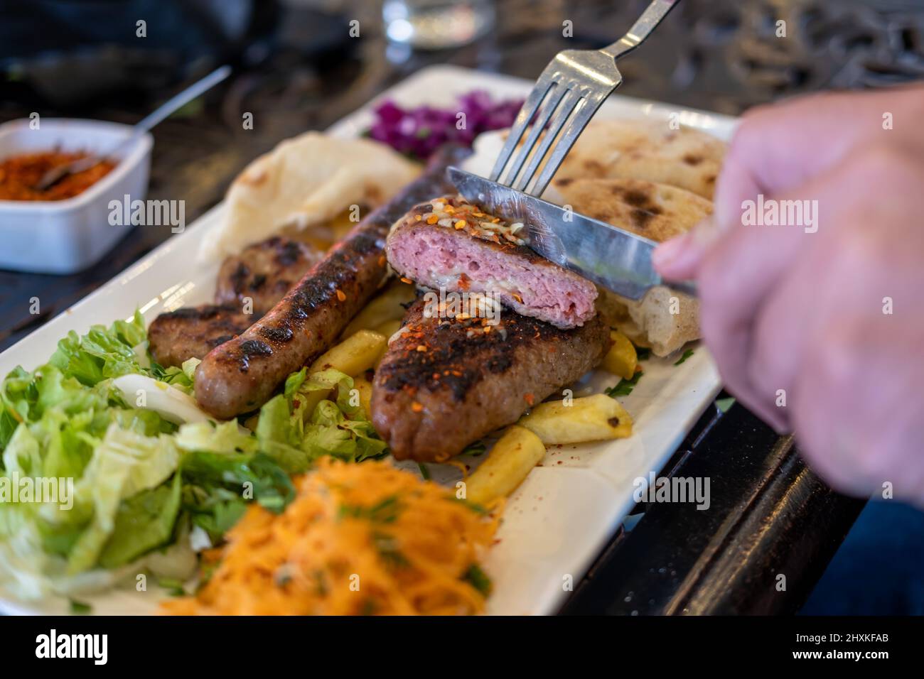 Different types of grilled or barbeque meat on the plate, cutting and ...