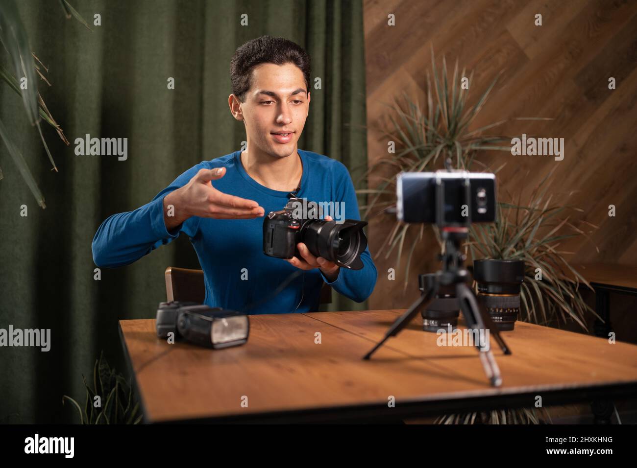 The guy photographer makes an overview of the camera settings and ...