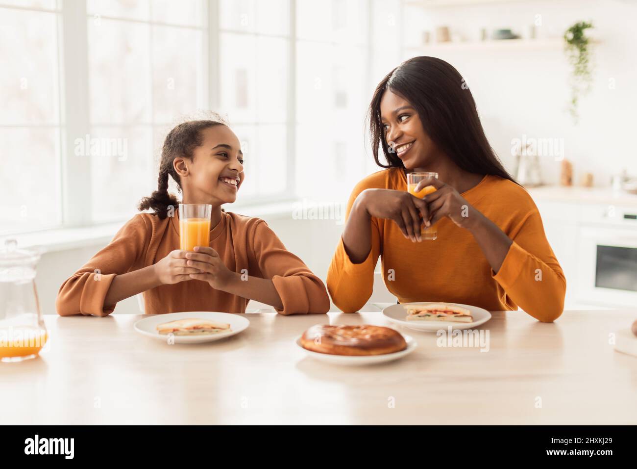 African Mommy And Daughter Having Lunch Drinking Juice In Kitchen Stock ...
