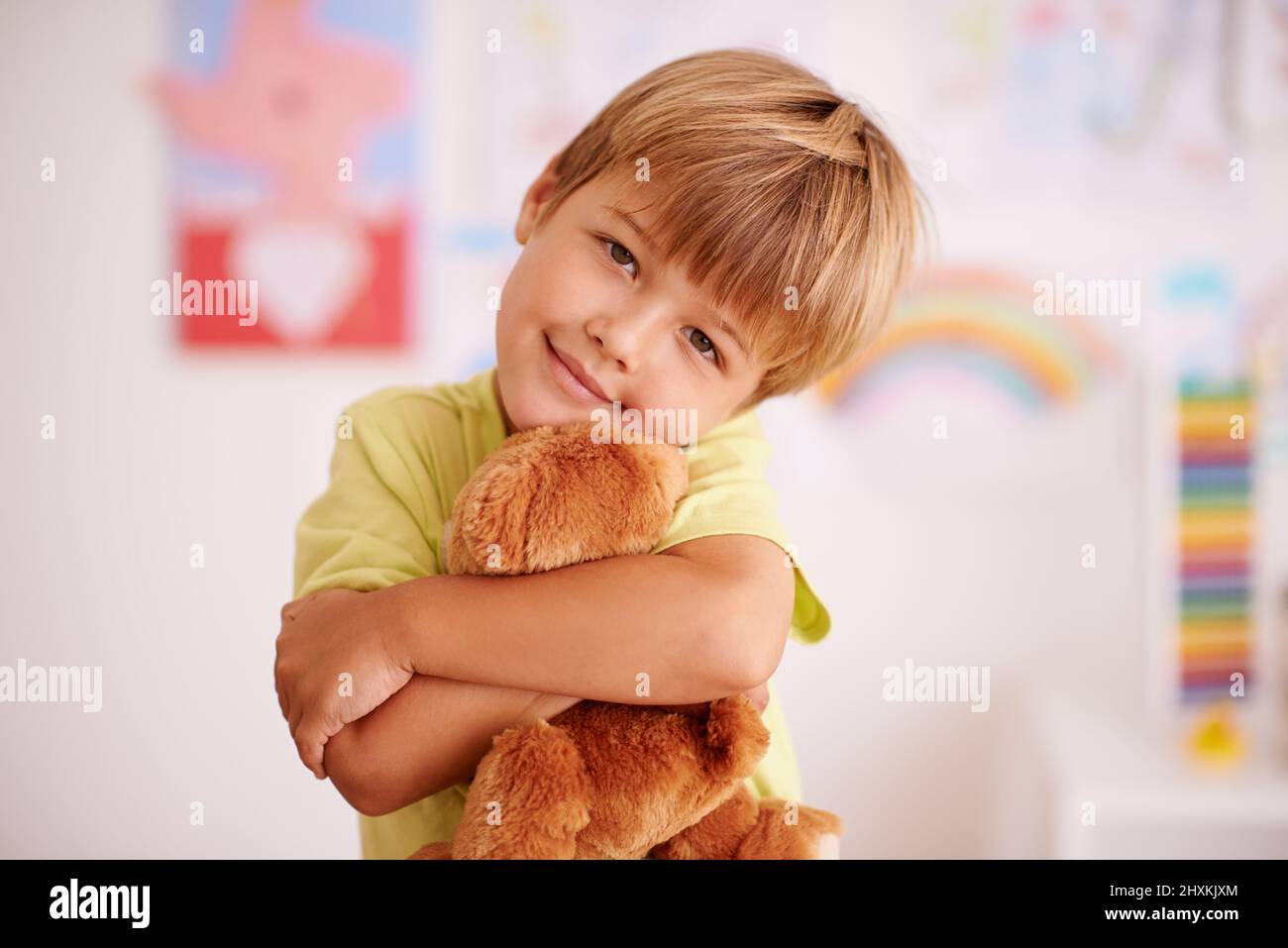 Childhood moments. Portrait of a cute little boy hugging his stuffed ...