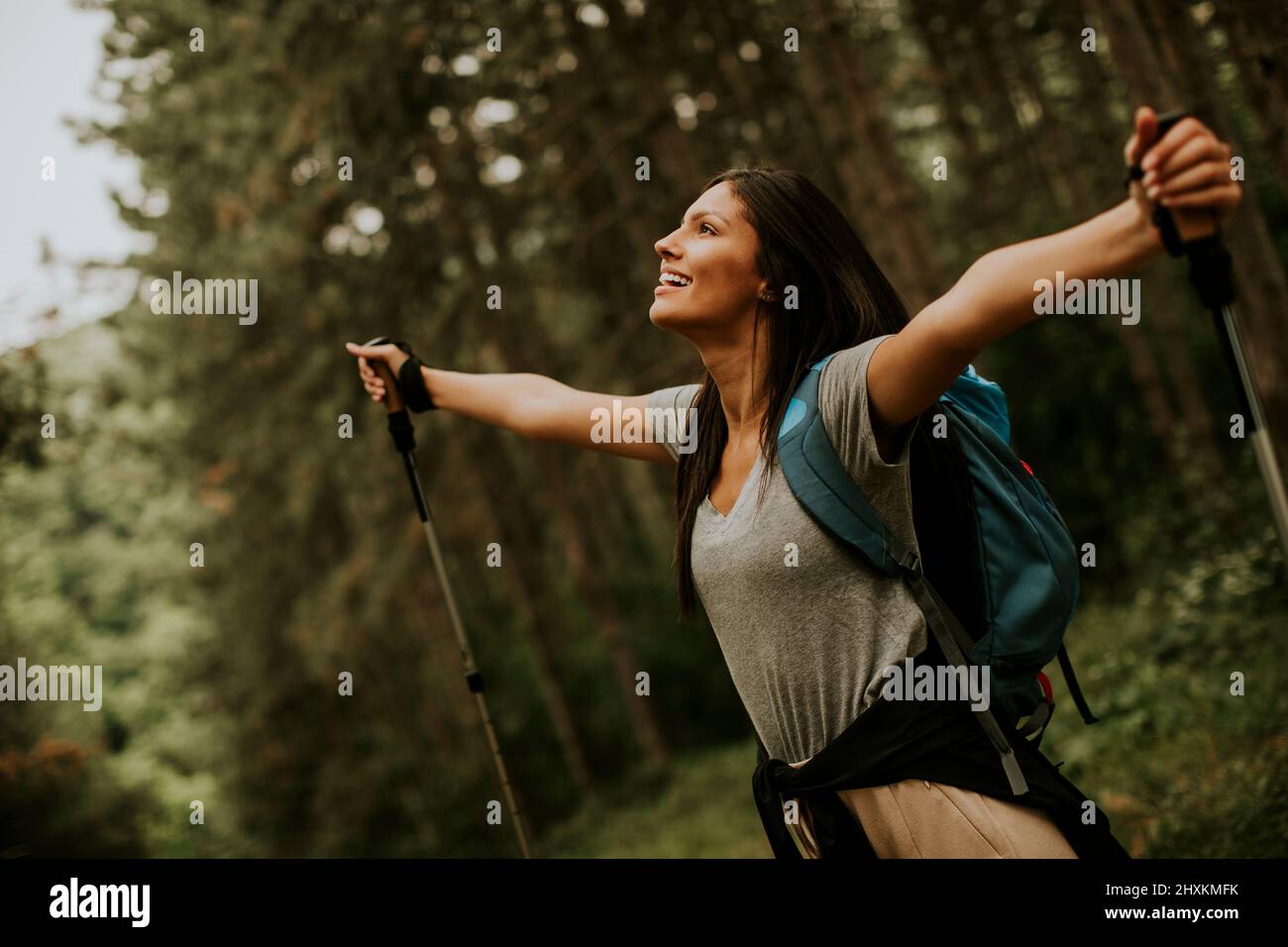 Pretty young female backpacker woman enjoying green beautiful forest ...